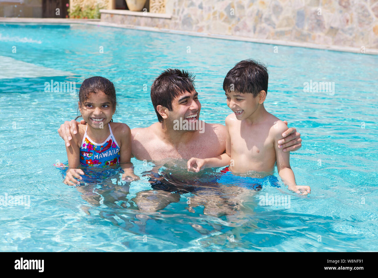Family enjoying in a swimming pool Stock Photo - Alamy