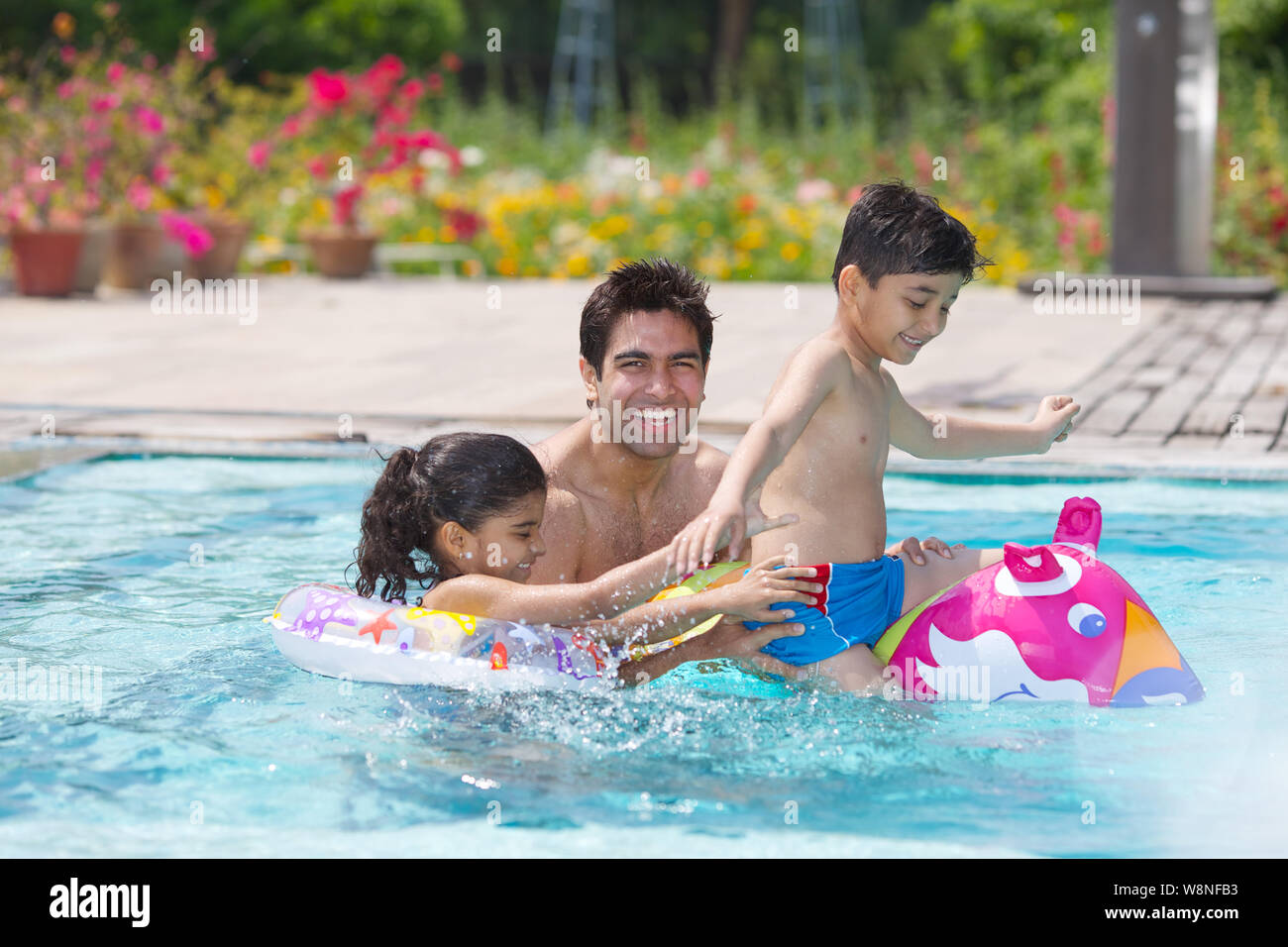 Family playing in a swimming pool Stock Photo - Alamy