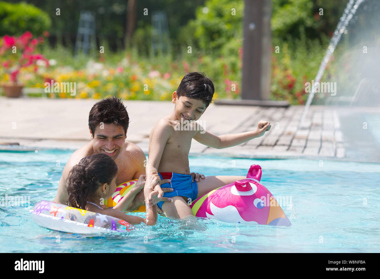 Family playing in a swimming pool Stock Photo - Alamy