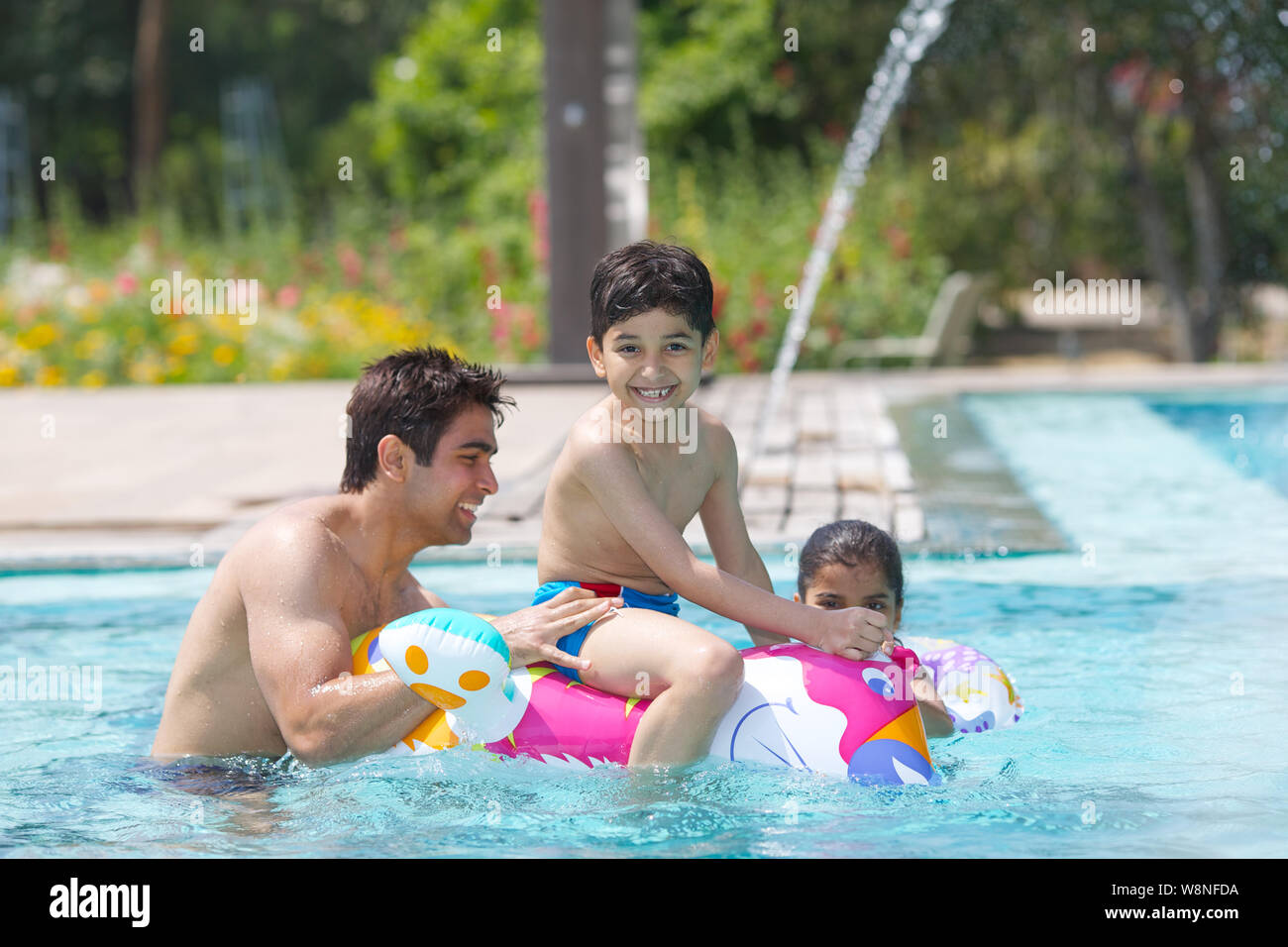 Family playing in a swimming pool Stock Photo - Alamy