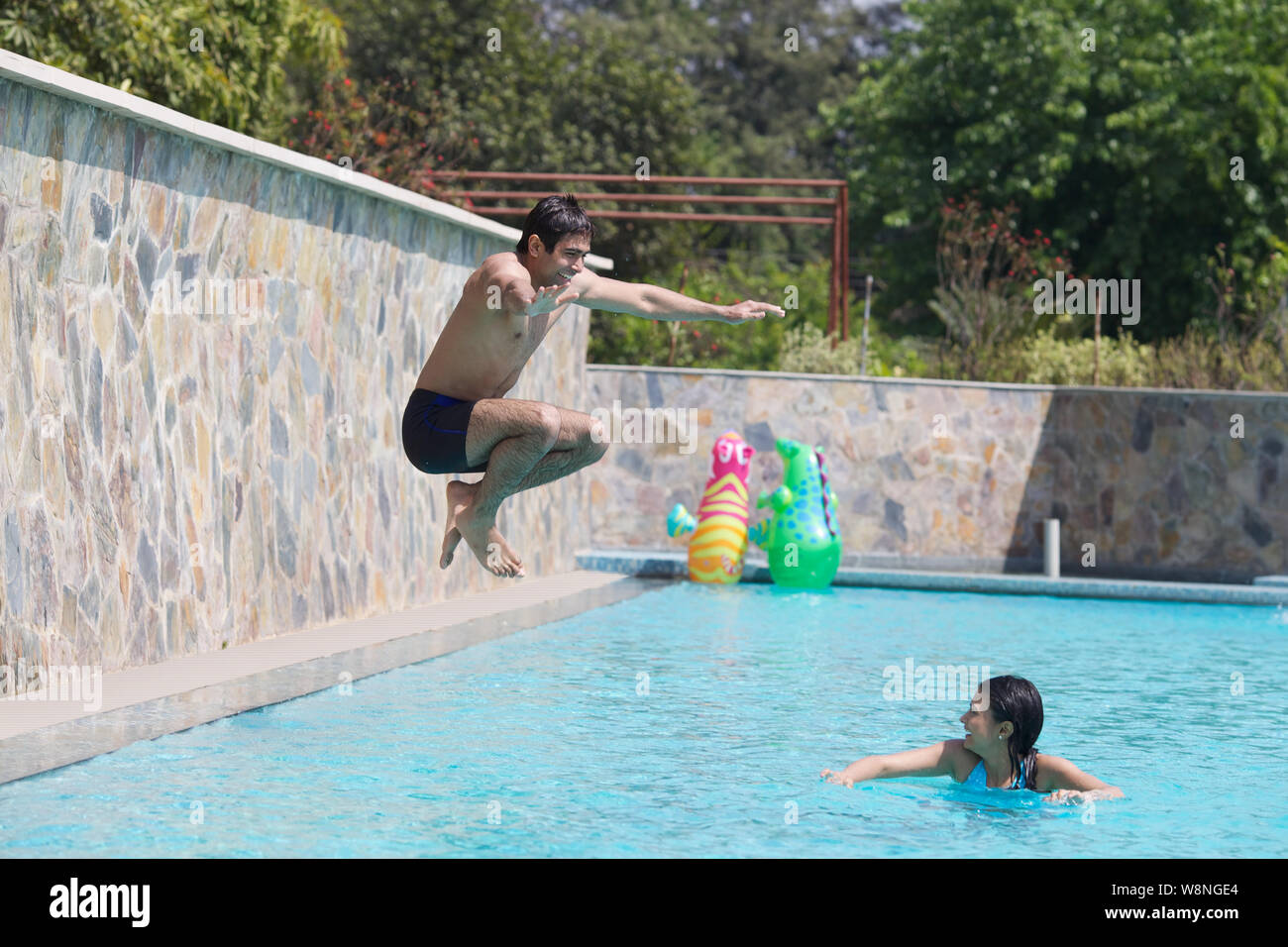 Couple jumping into pool hi-res stock photography and images - Alamy