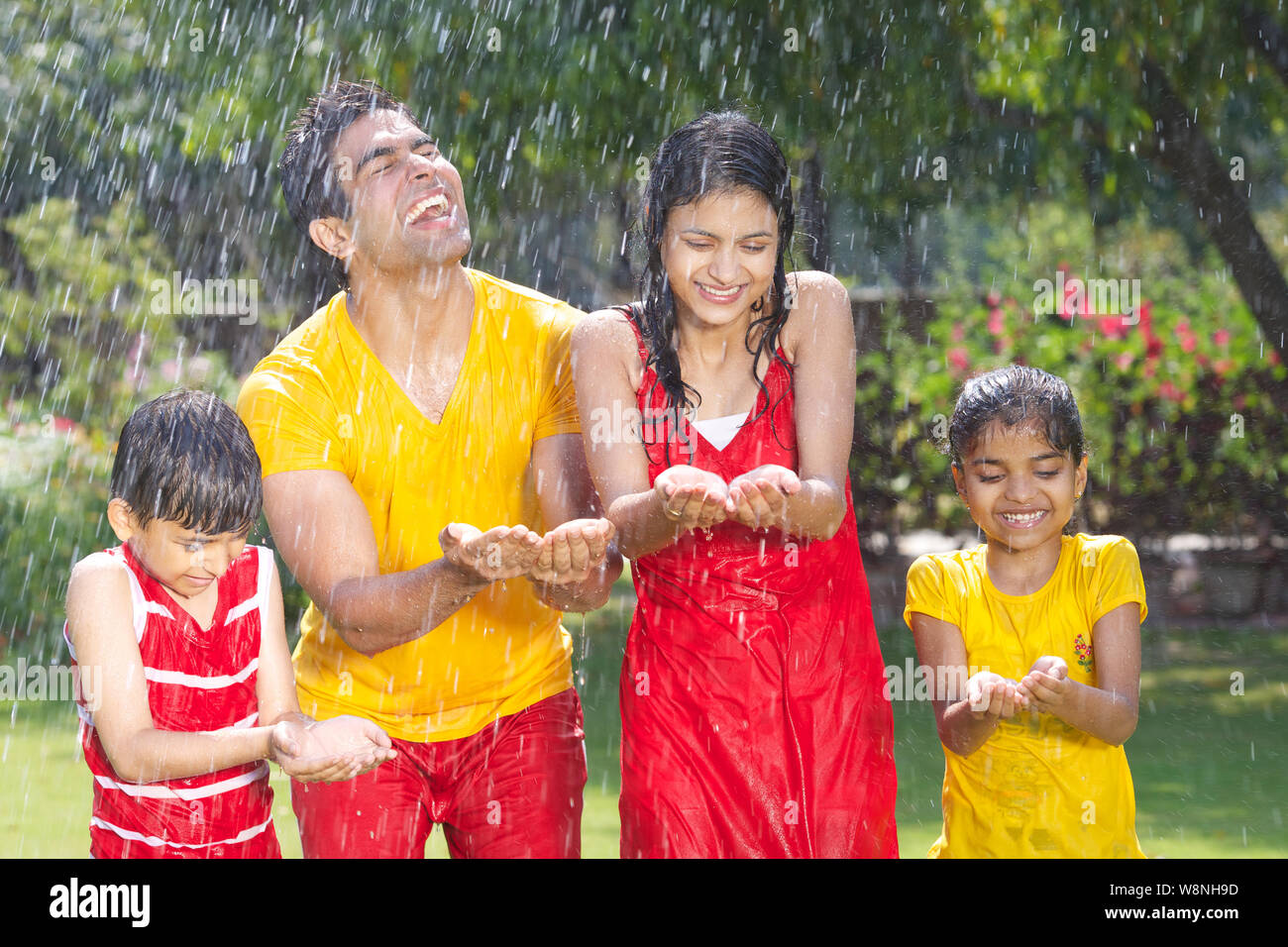 Family enjoying rain in a garden Stock Photo - Alamy