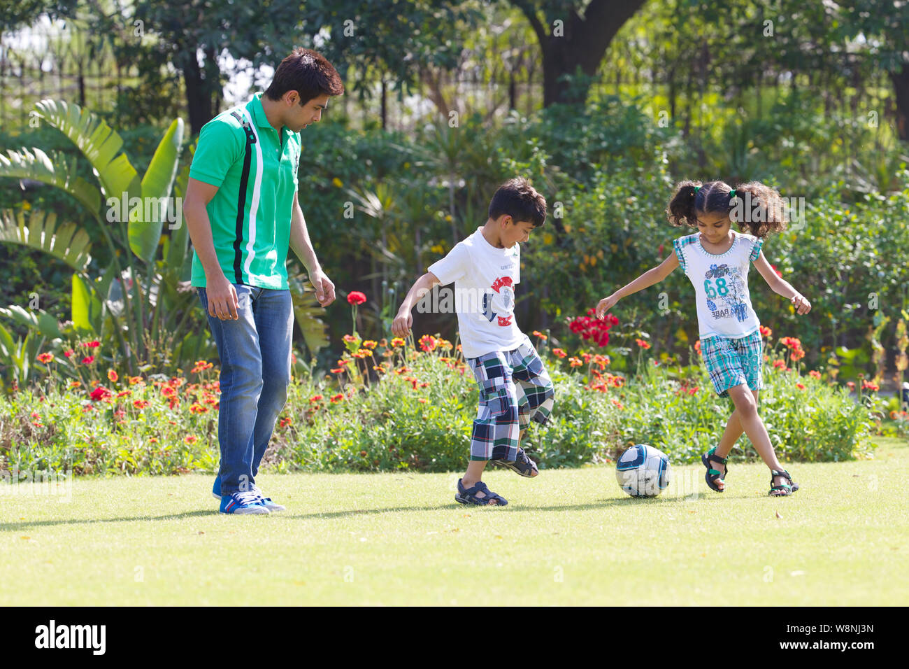 Family playing soccer in a garden Stock Photo - Alamy