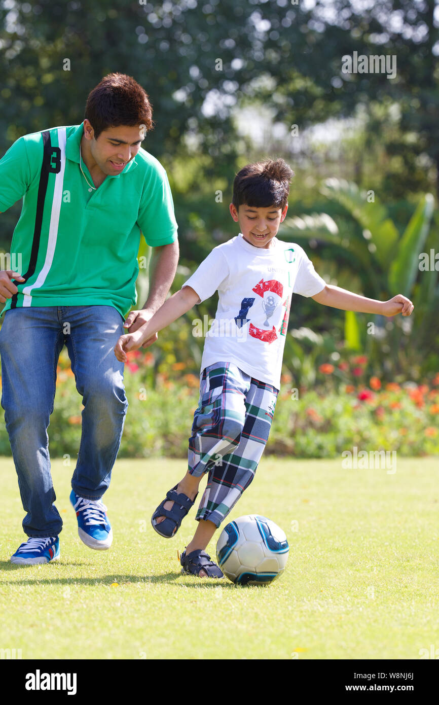 Father and son playing soccer in a garden Stock Photo - Alamy