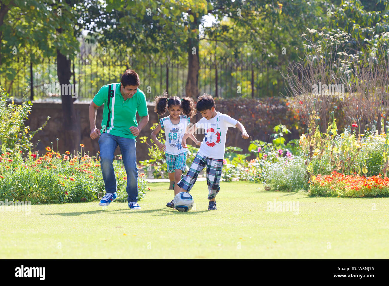 Family playing soccer in a garden Stock Photo - Alamy