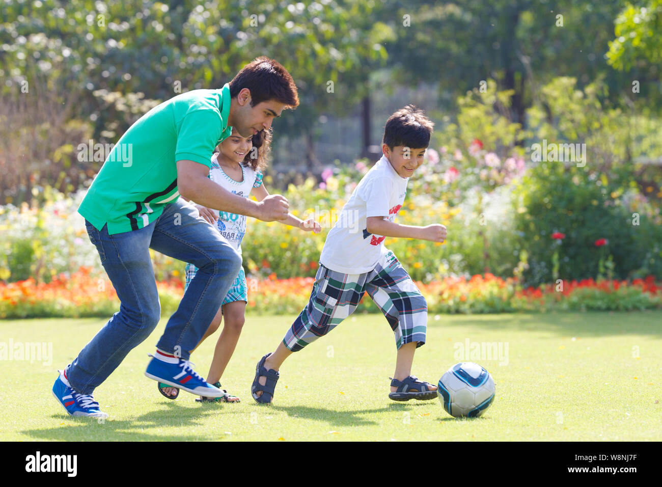 Family playing soccer in a garden Stock Photo - Alamy