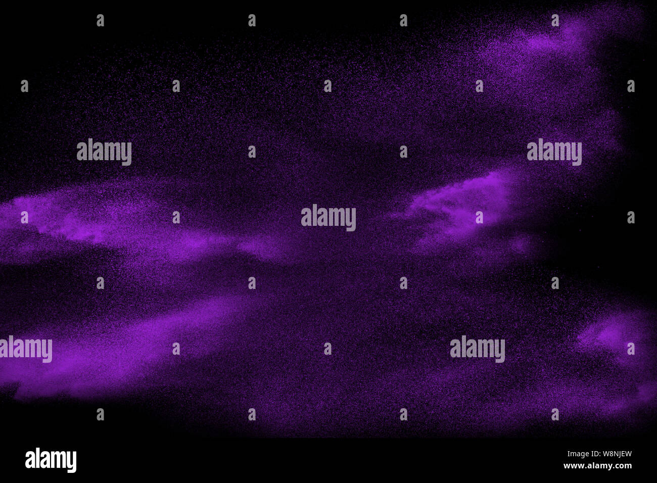 Purple particle dust splash on black background. Purple powder ...