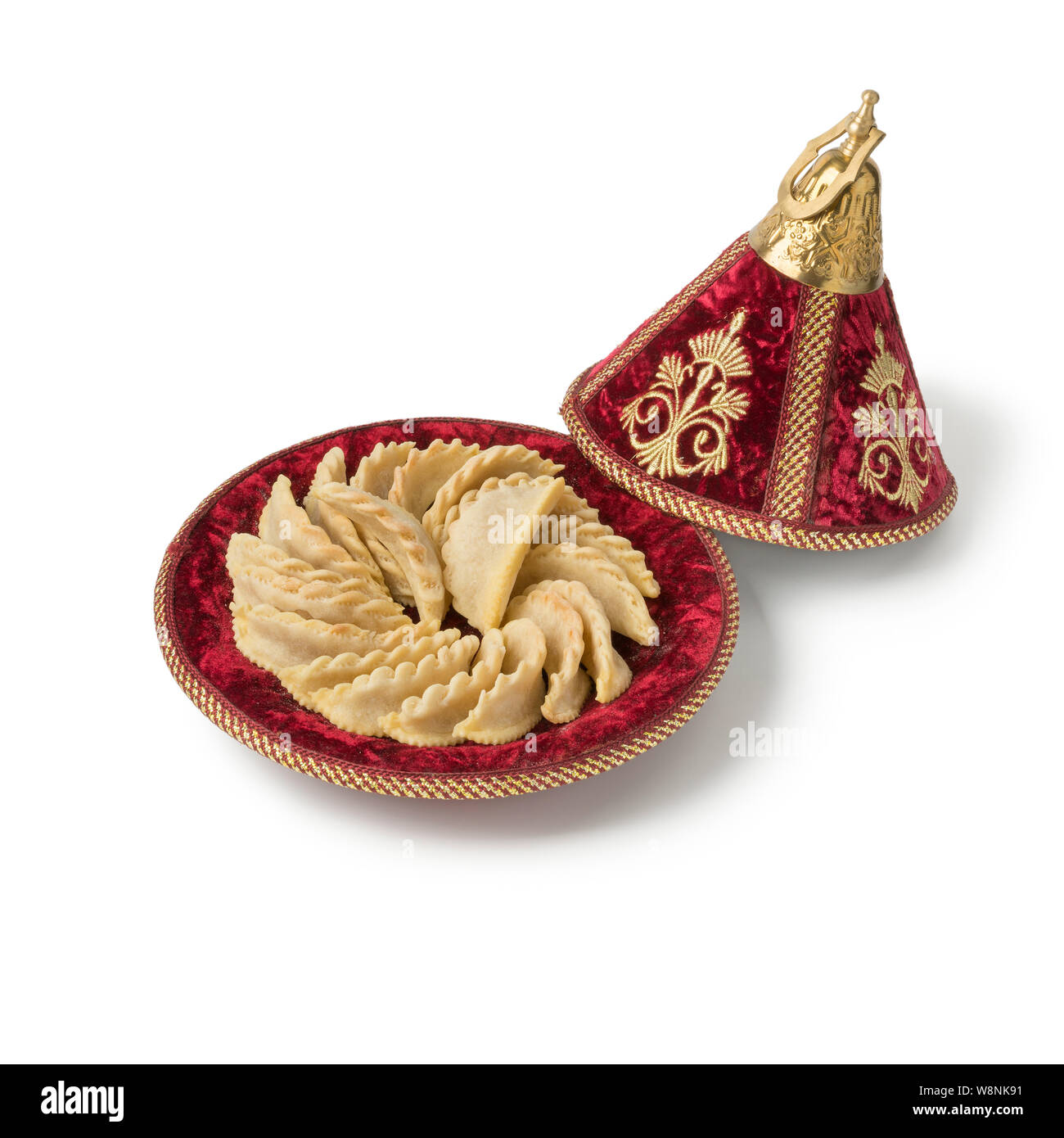 Traditional Gazelle Horns cookies in a festive tagine isolated on white ...