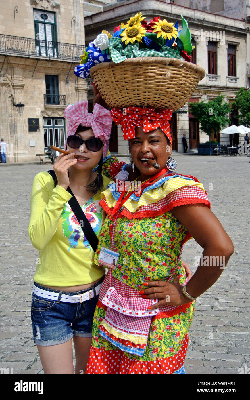 colorful street scene of pretty tourist smoking cuban cigar with local ...