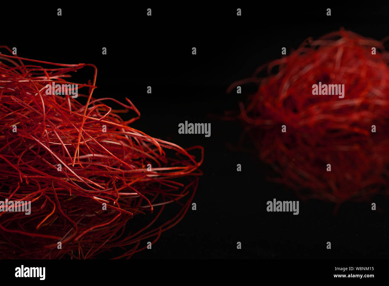 Lot of whole red chili pepper threads two stacks isolated on black ...