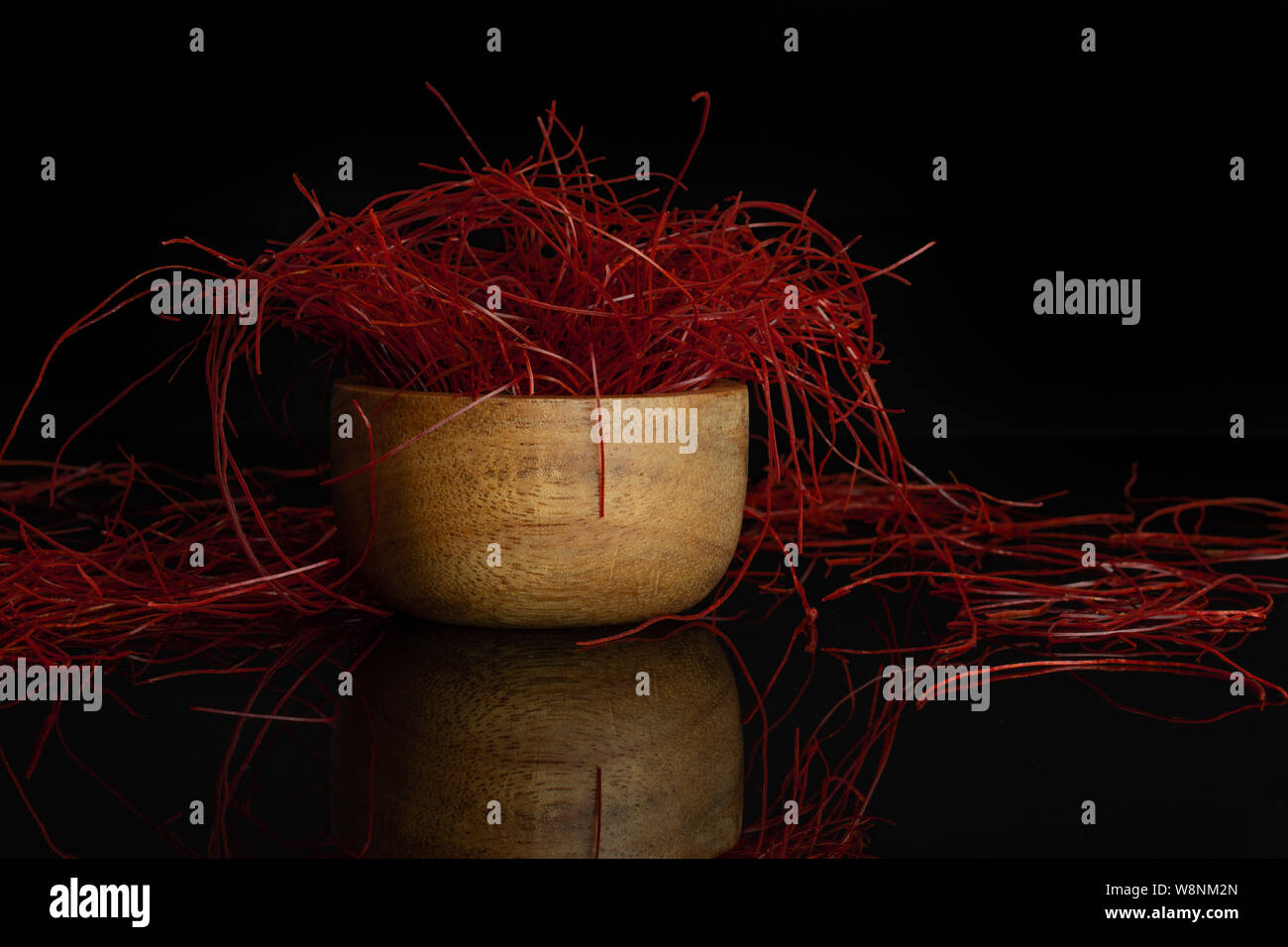 Lot of whole red chili pepper threads in wooden bowl isolated on black ...