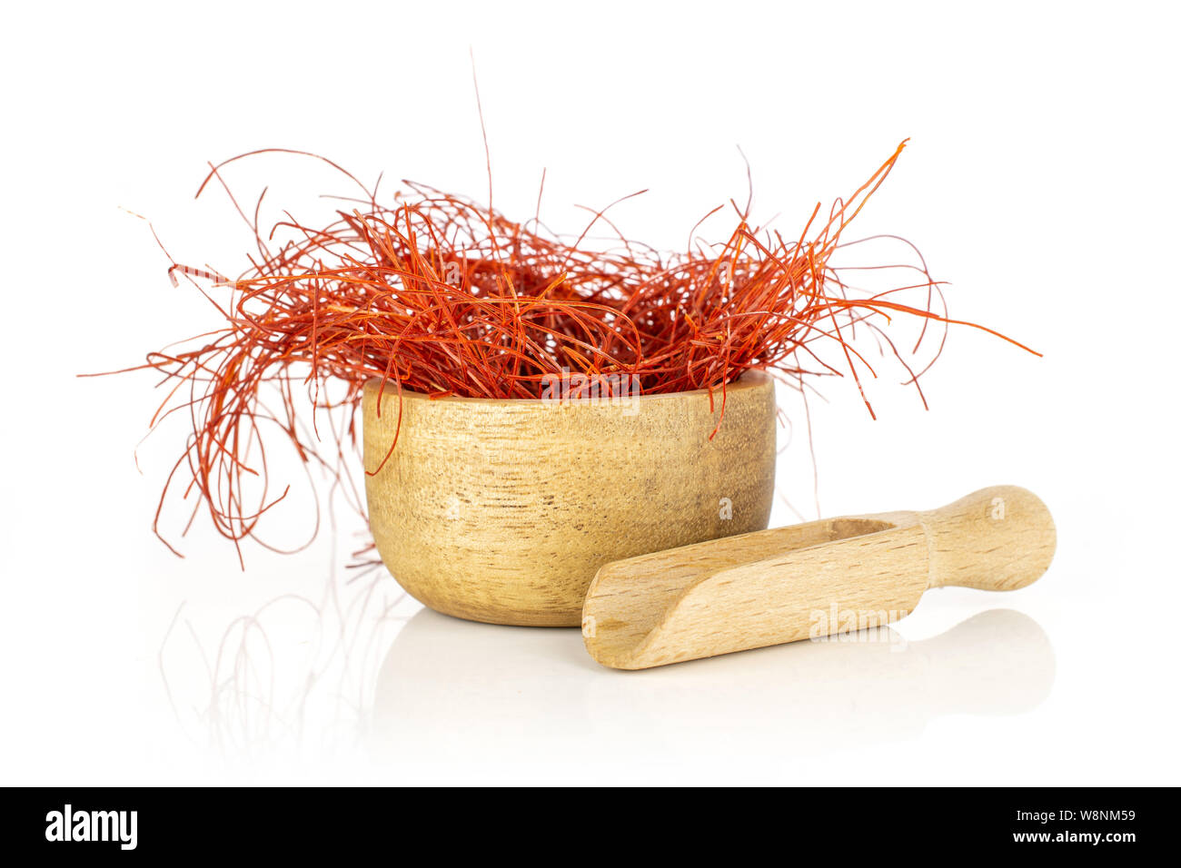 Lot of whole red chili pepper threads in wooden bowl with wooden scoop ...