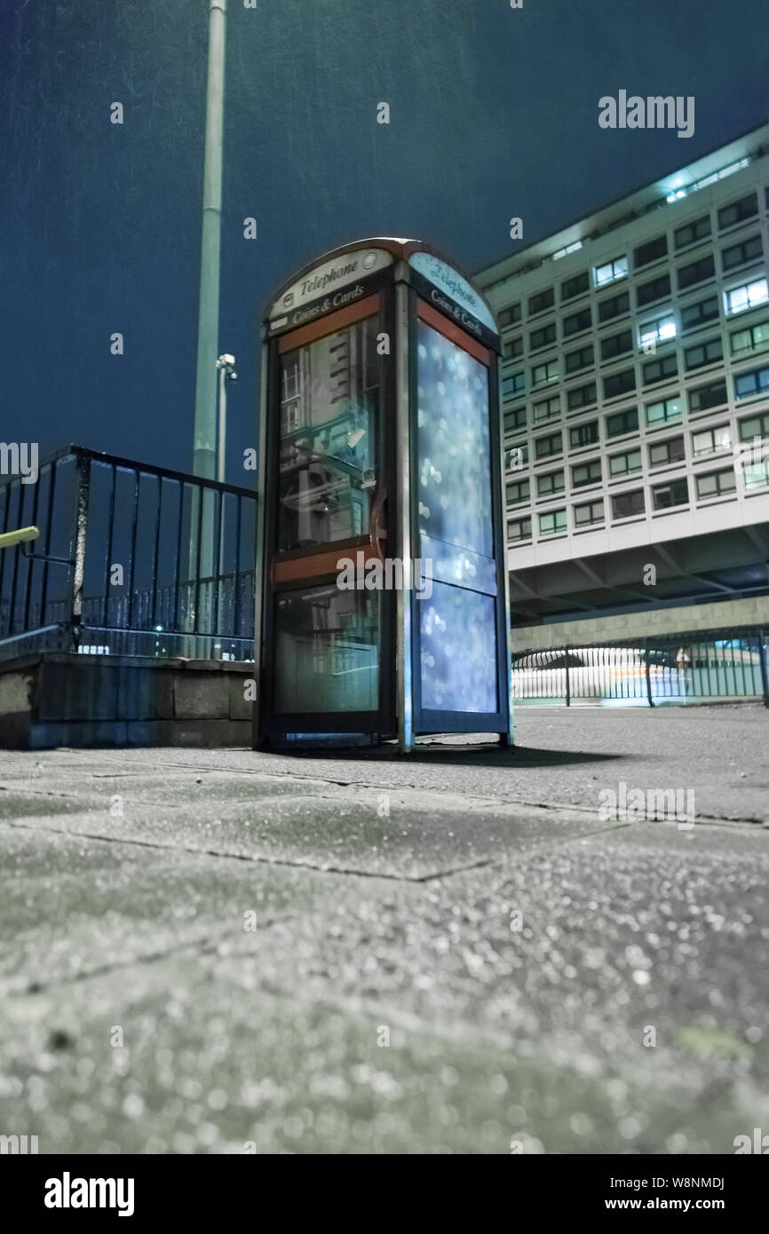 Modern UK telephone box or booth at night in the rain, in Newcastle ...