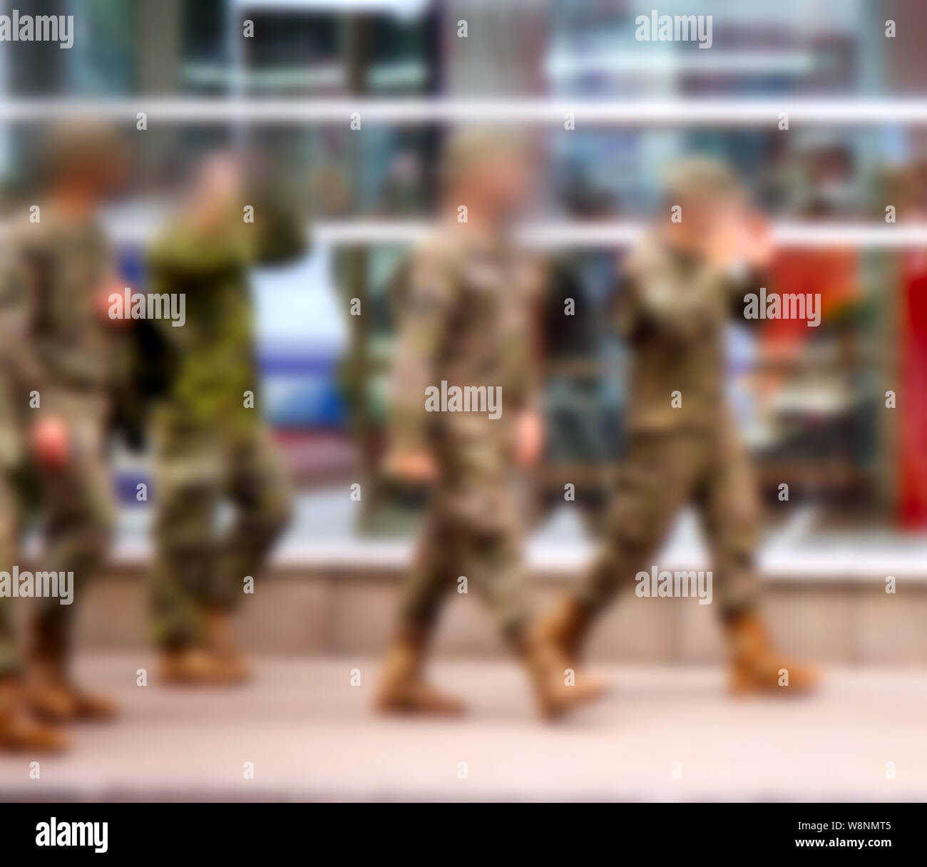 Strong blur, anonymous military men in uniform on streets of Europe ...