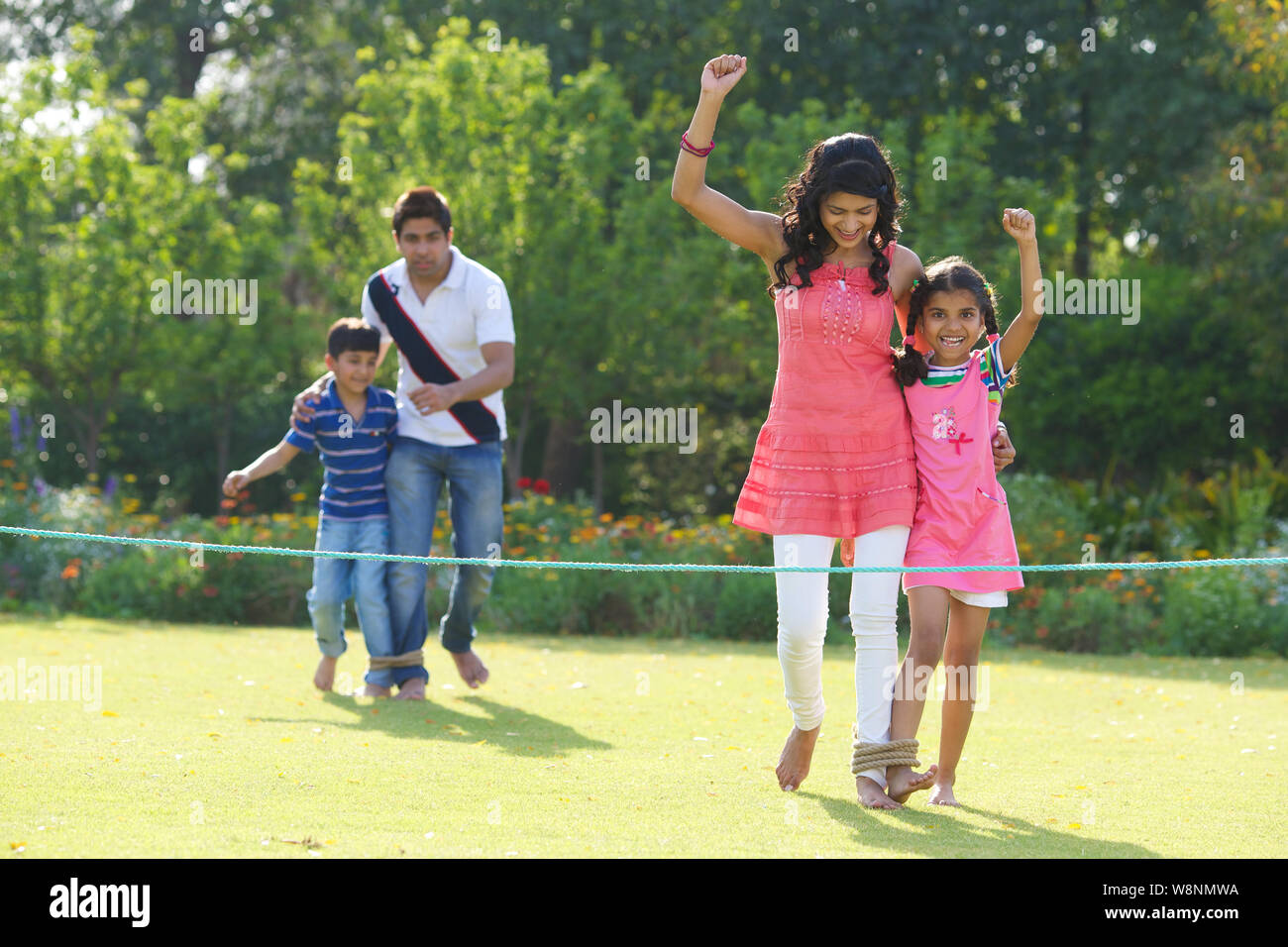 Family playing three legged race in a garden Stock Photo - Alamy