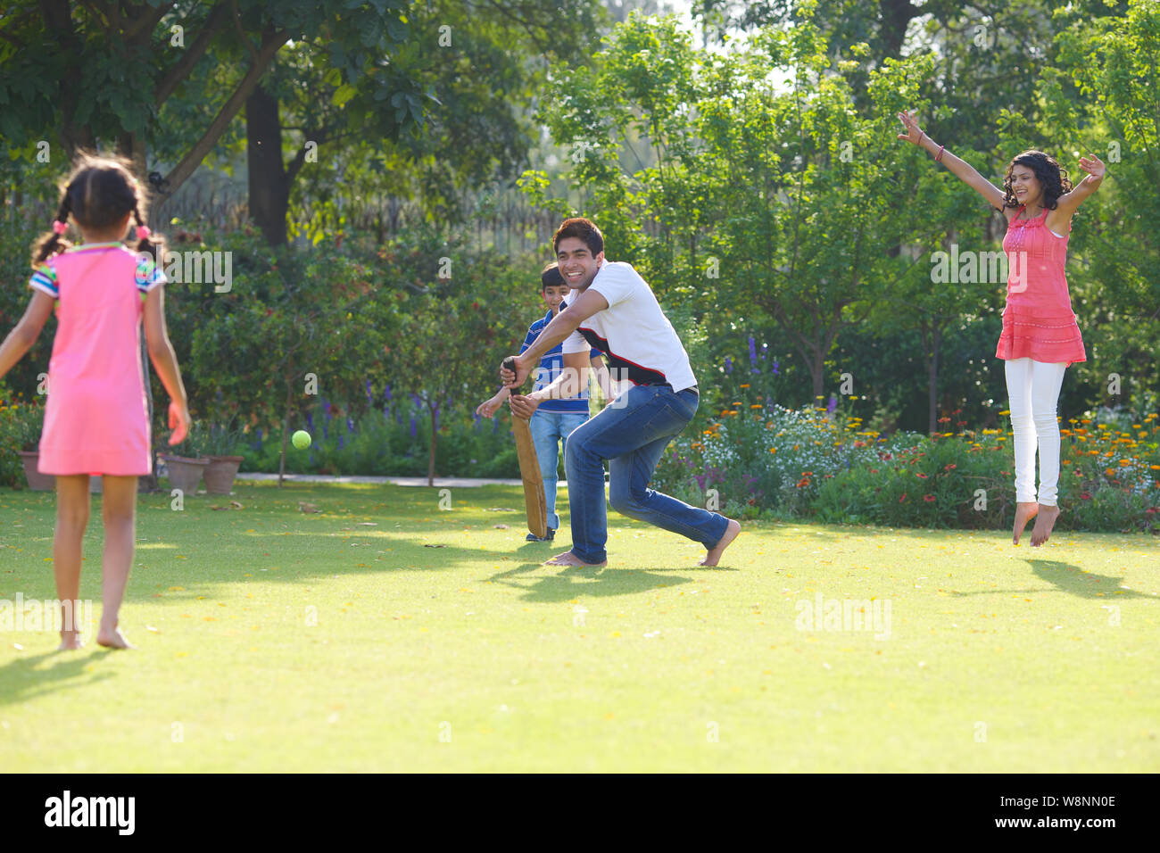 Family playing cricket in a garden Stock Photo - Alamy