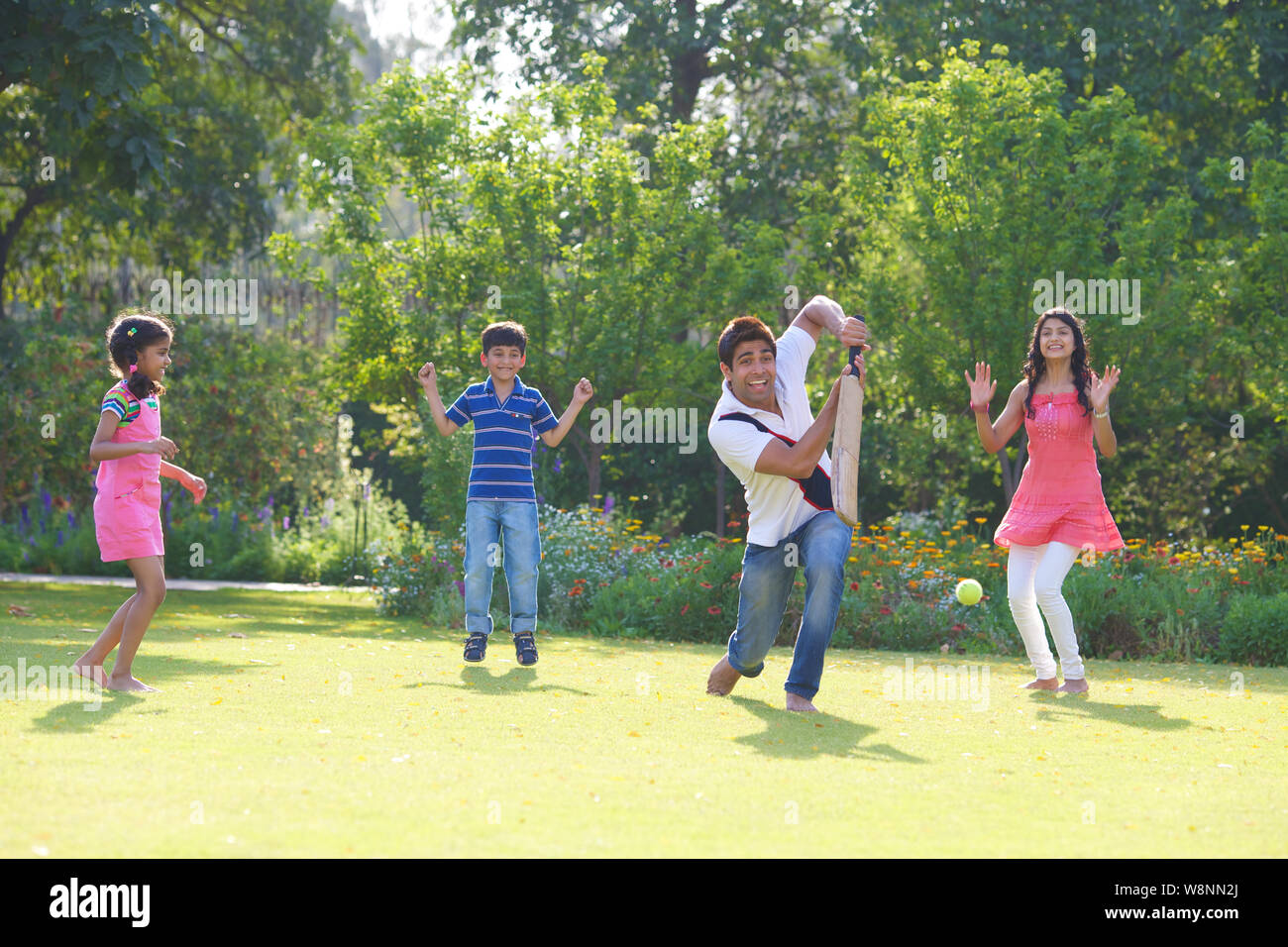 Family playing cricket in a garden Stock Photo - Alamy