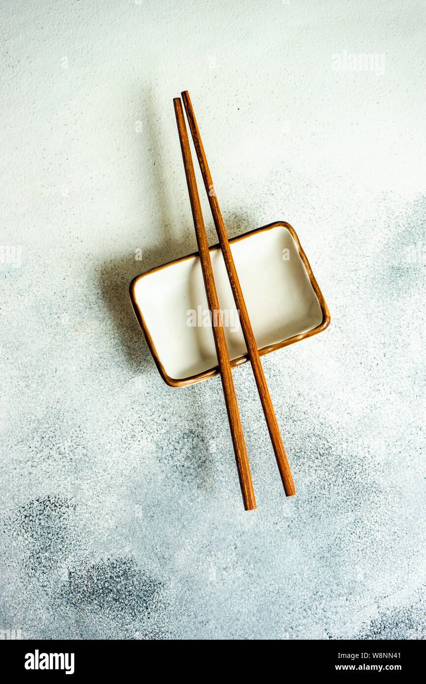 Asian table setting with ceramic bowl and wooden chopsticks on stone ...