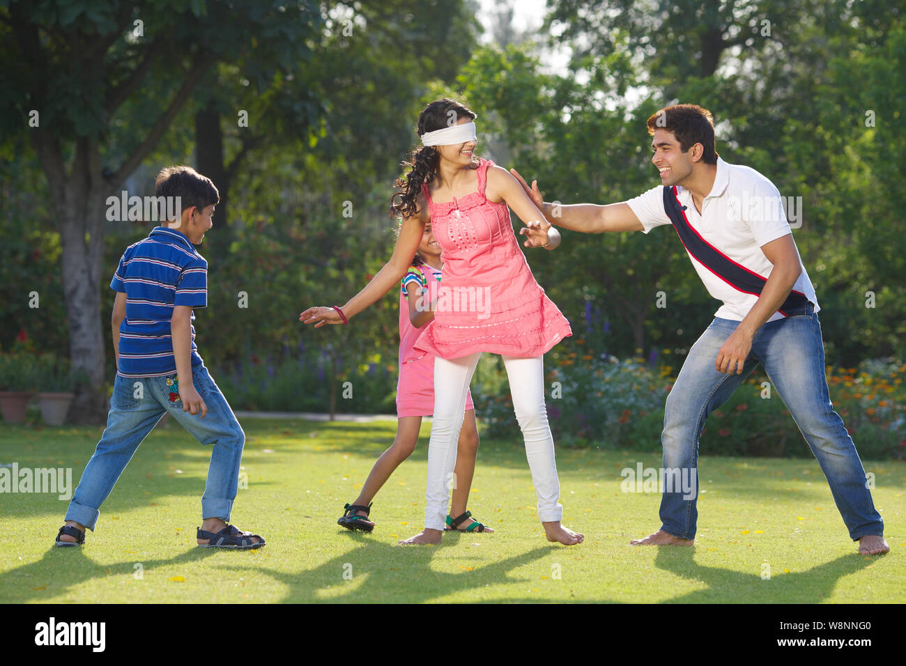 Family playing blind man bluff in a garden Stock Photo - Alamy