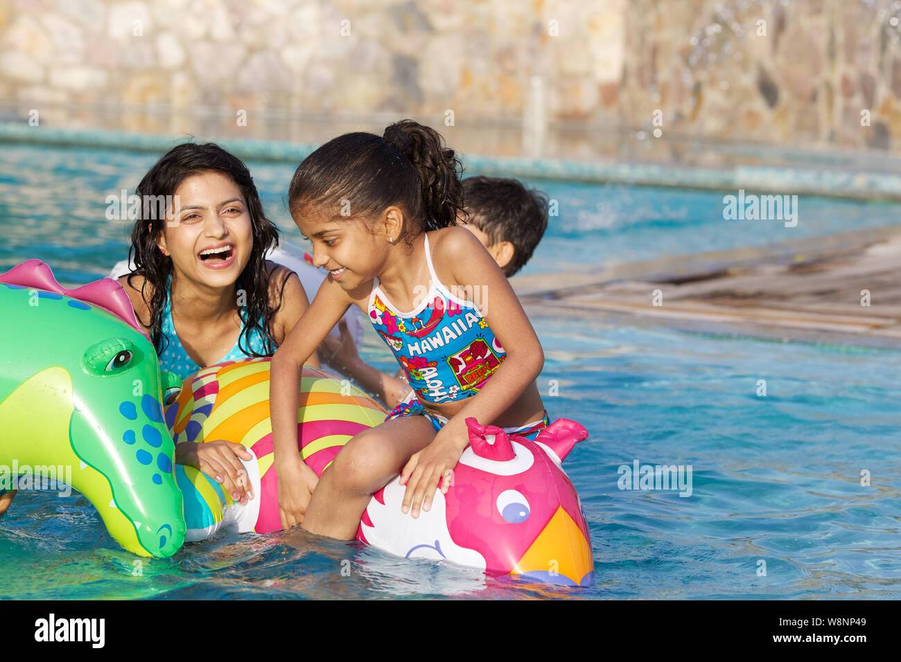 Family playing in a swimming pool Stock Photo - Alamy