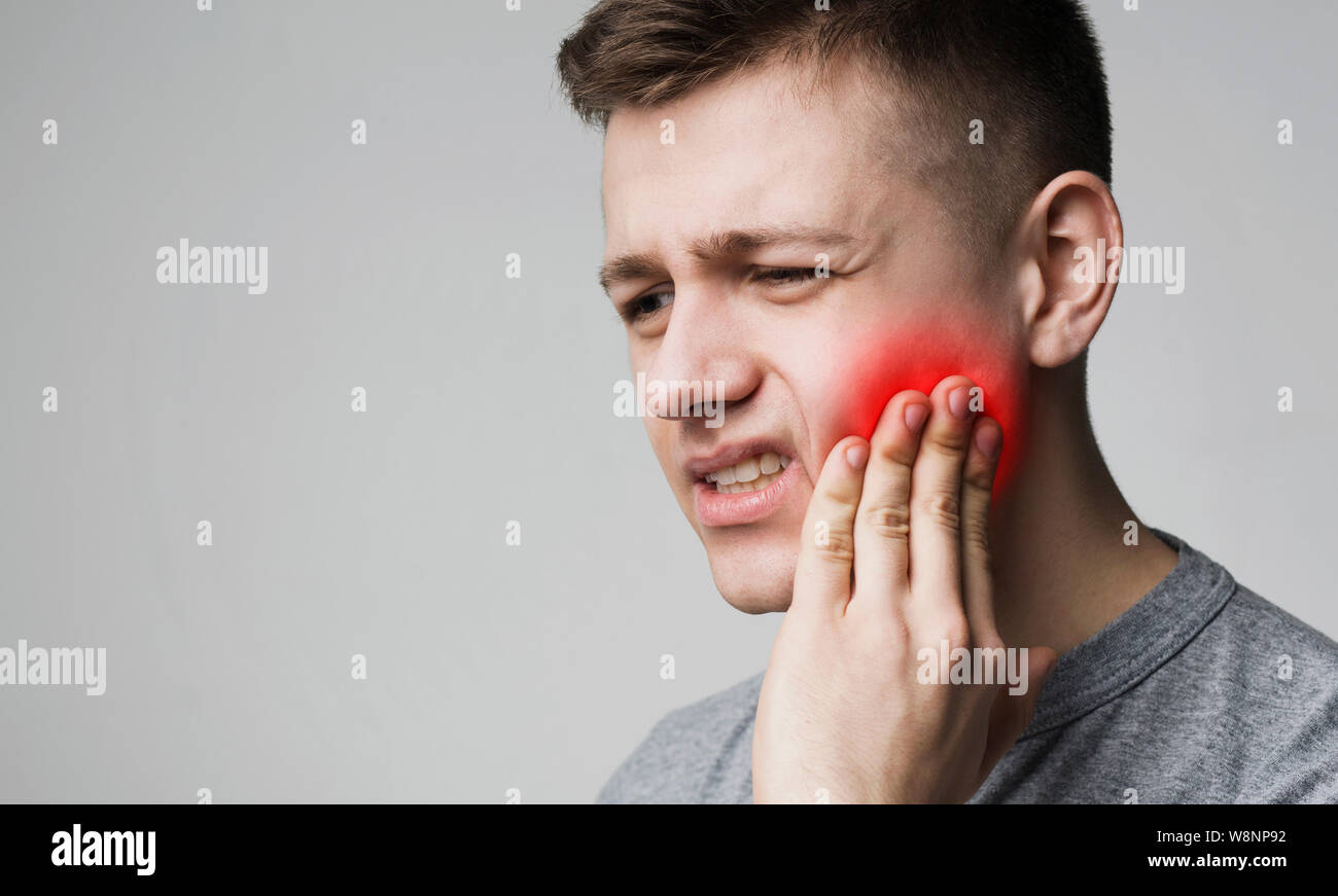 Frustrated young man touching his tooth and frowning face Stock Photo ...