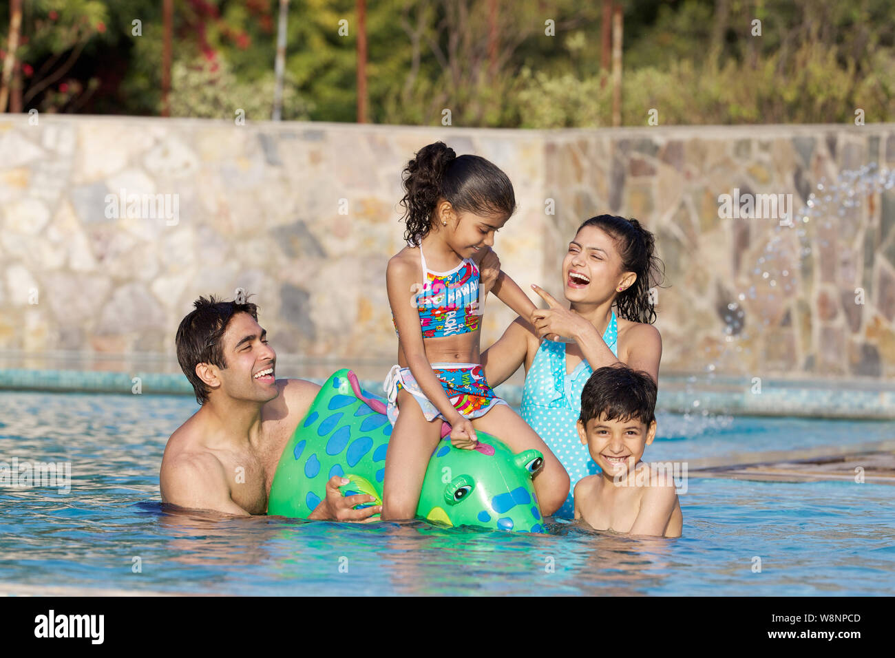 Family playing in a swimming pool Stock Photo - Alamy