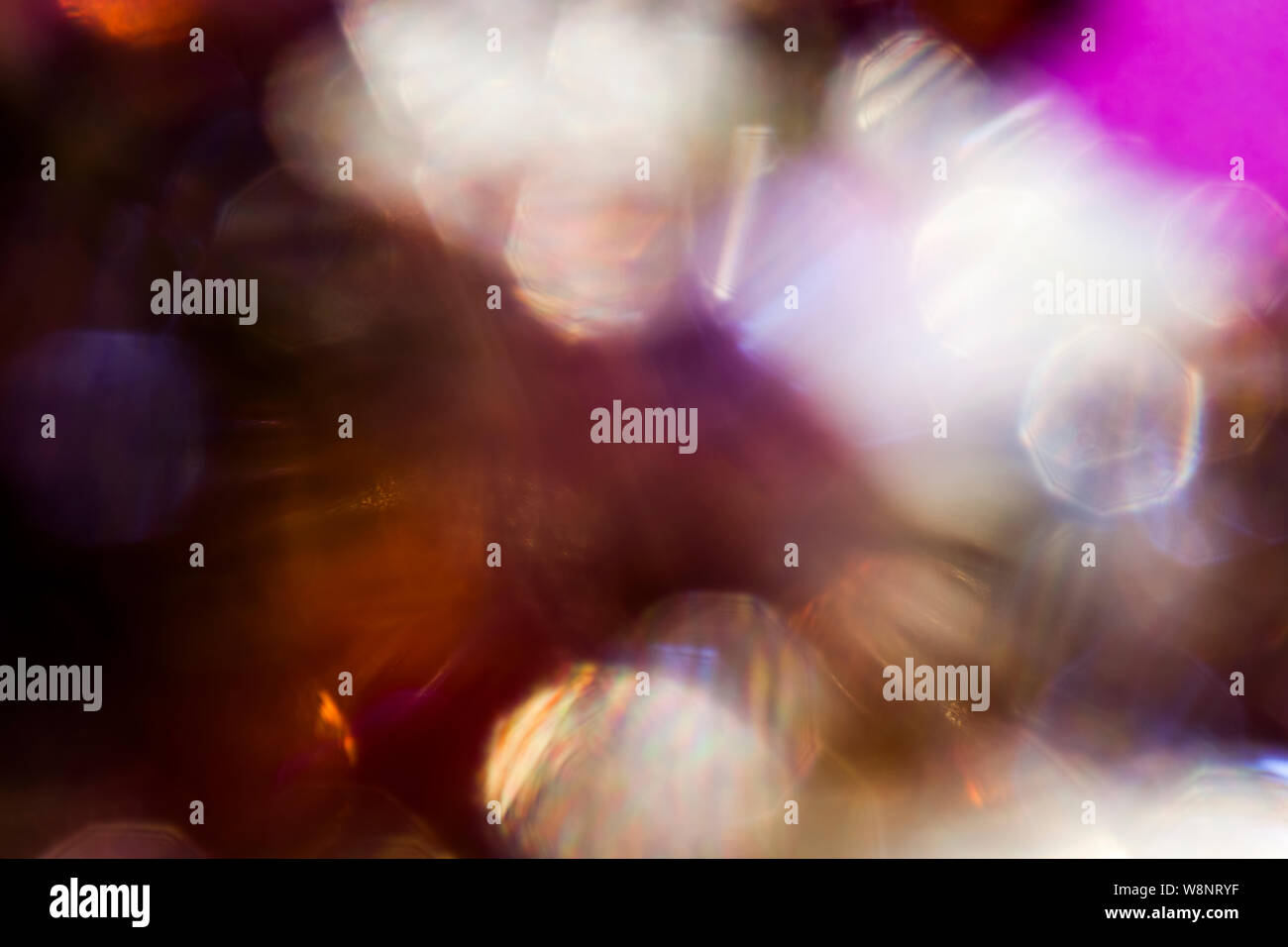 Closeup shot of smooth colorful specks of bright light shining on dark ...