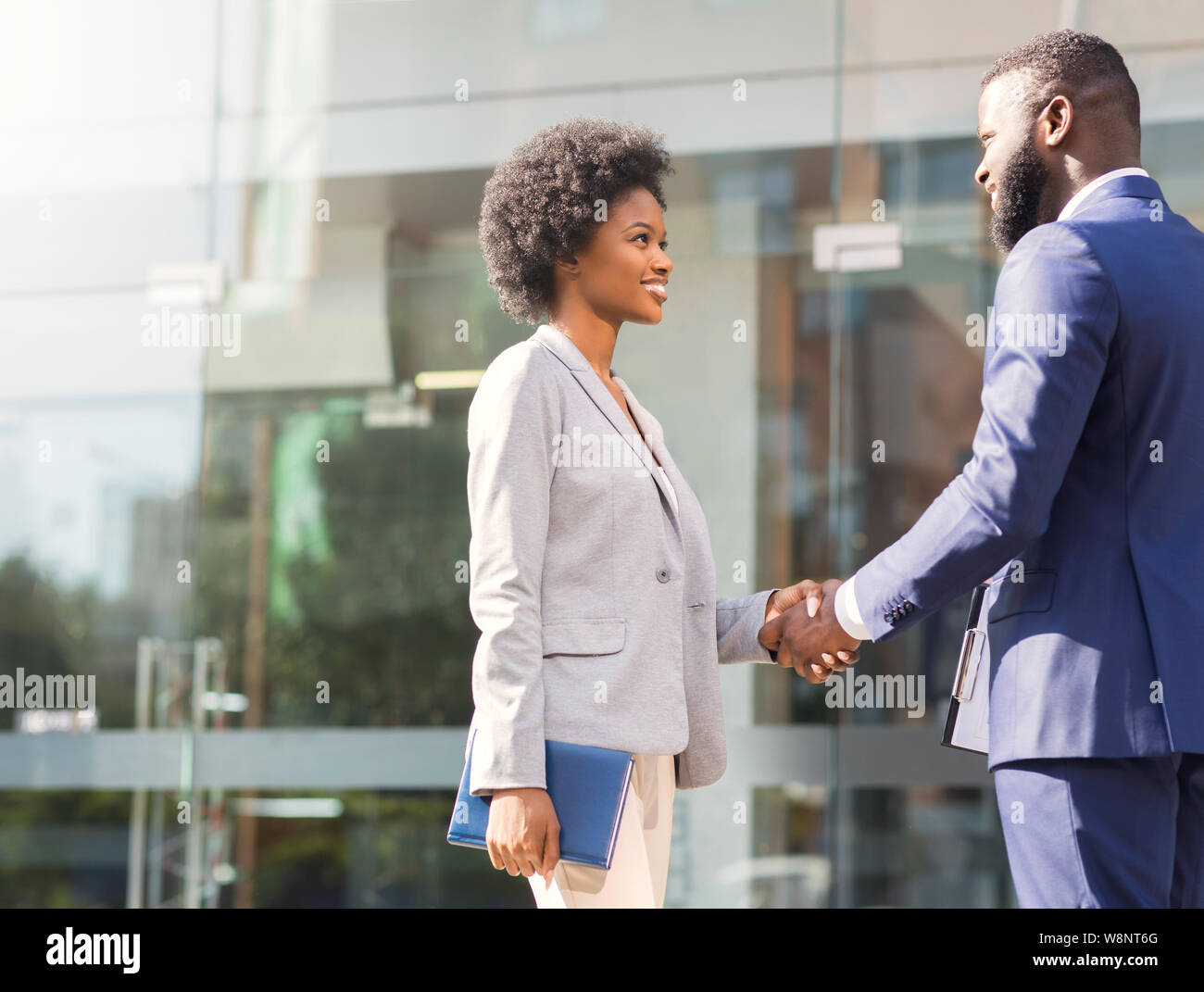 Nice to meet you. Two african business people introducing outdoors ...
