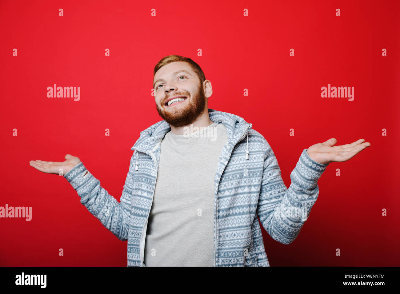 Handsome young guy with ginger beard smiling and looking up while ...