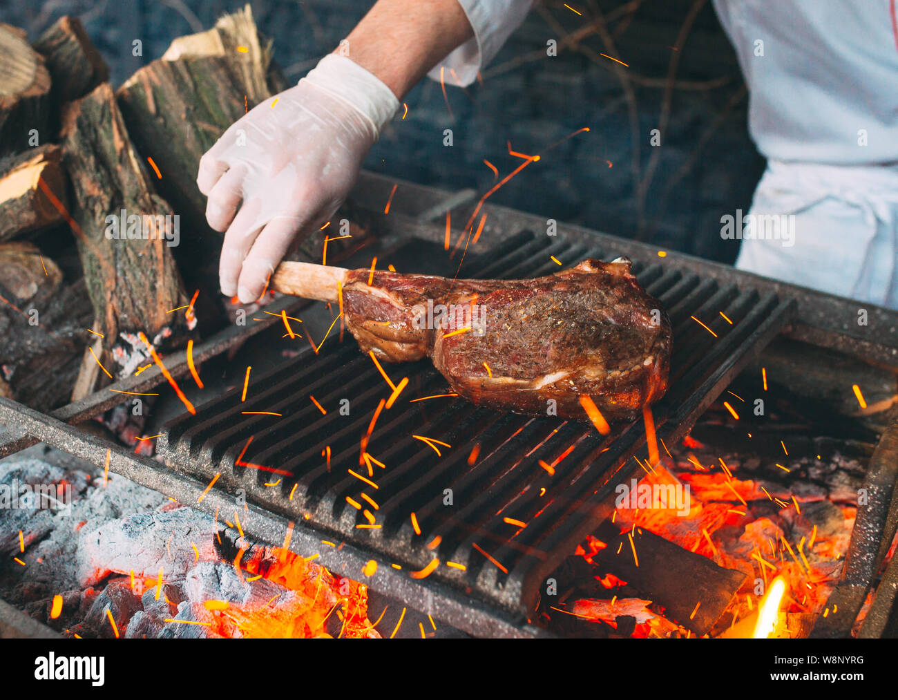 Chef Cooking steak. Cook turns the meat on the fire Stock Photo - Alamy