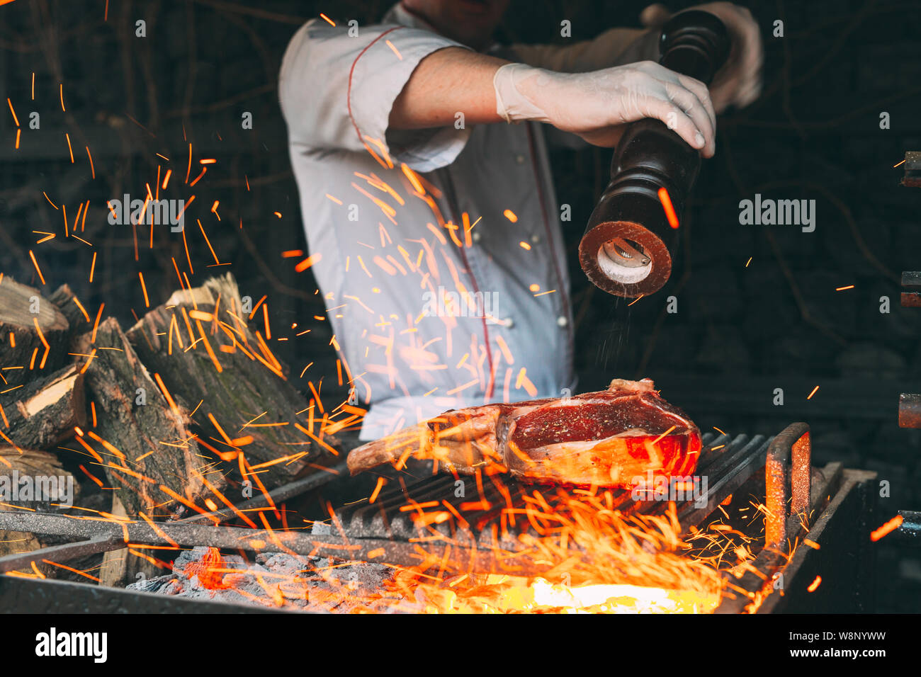 Chef pepper the steak on a fire Stock Photo - Alamy