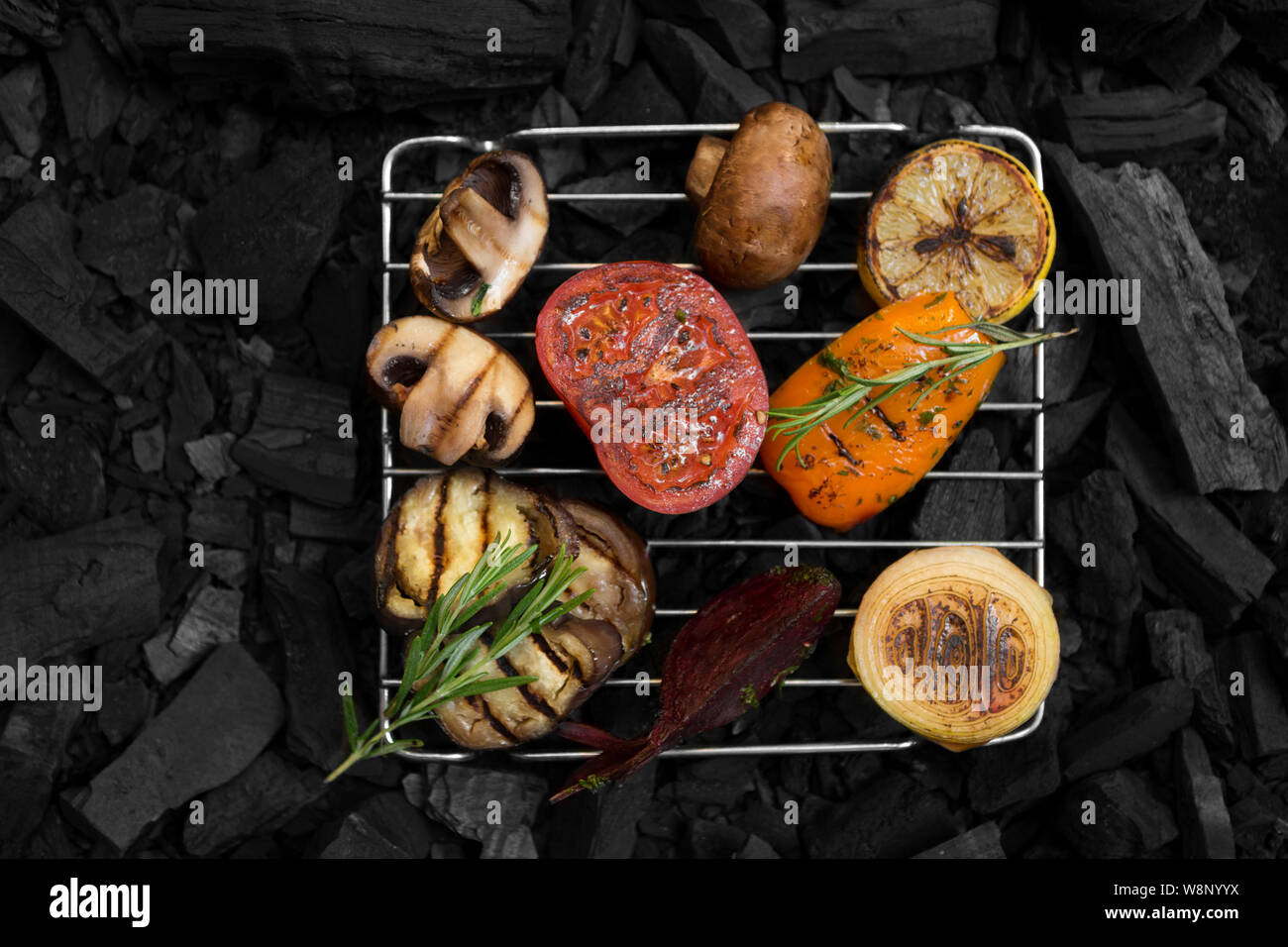 Preparing of grilled fresh vegetables on grid on coal background Stock ...
