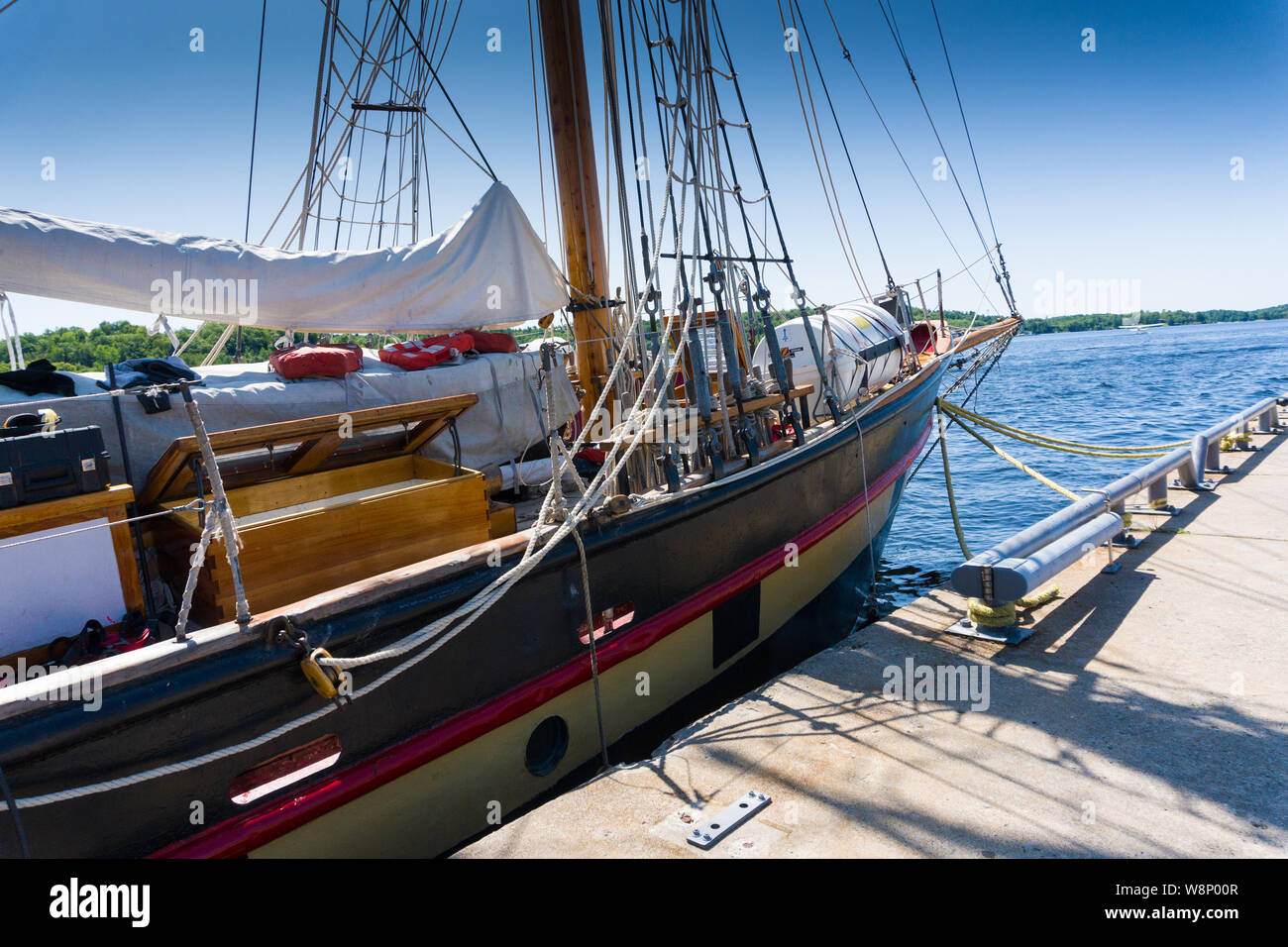 A large sailboat Brig stands on the pier at the pier and is loading to ...