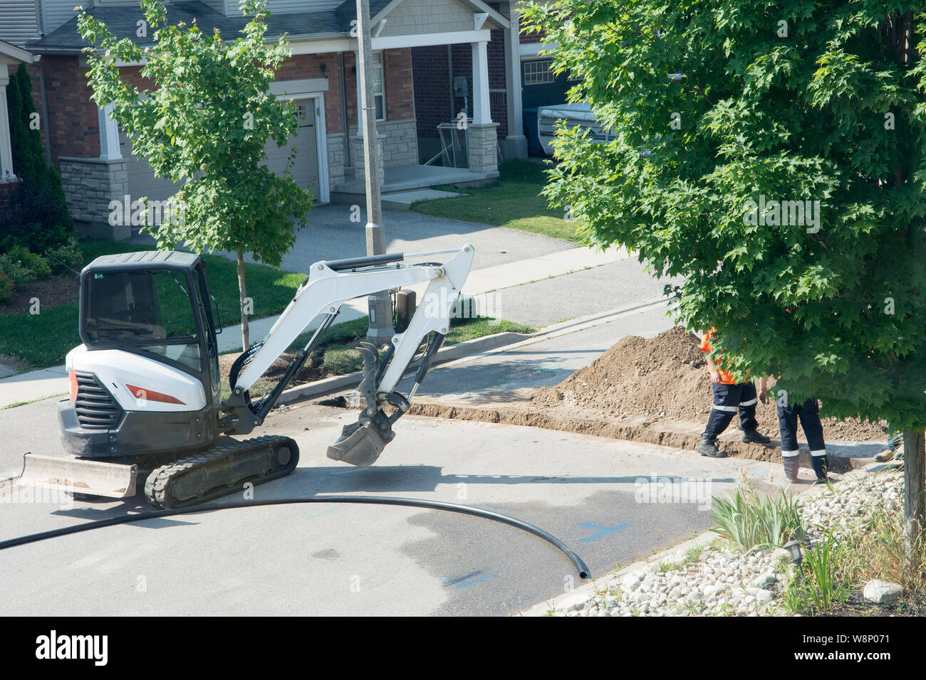 cable laying with optical fiber through a trench dug through an asphalt ...