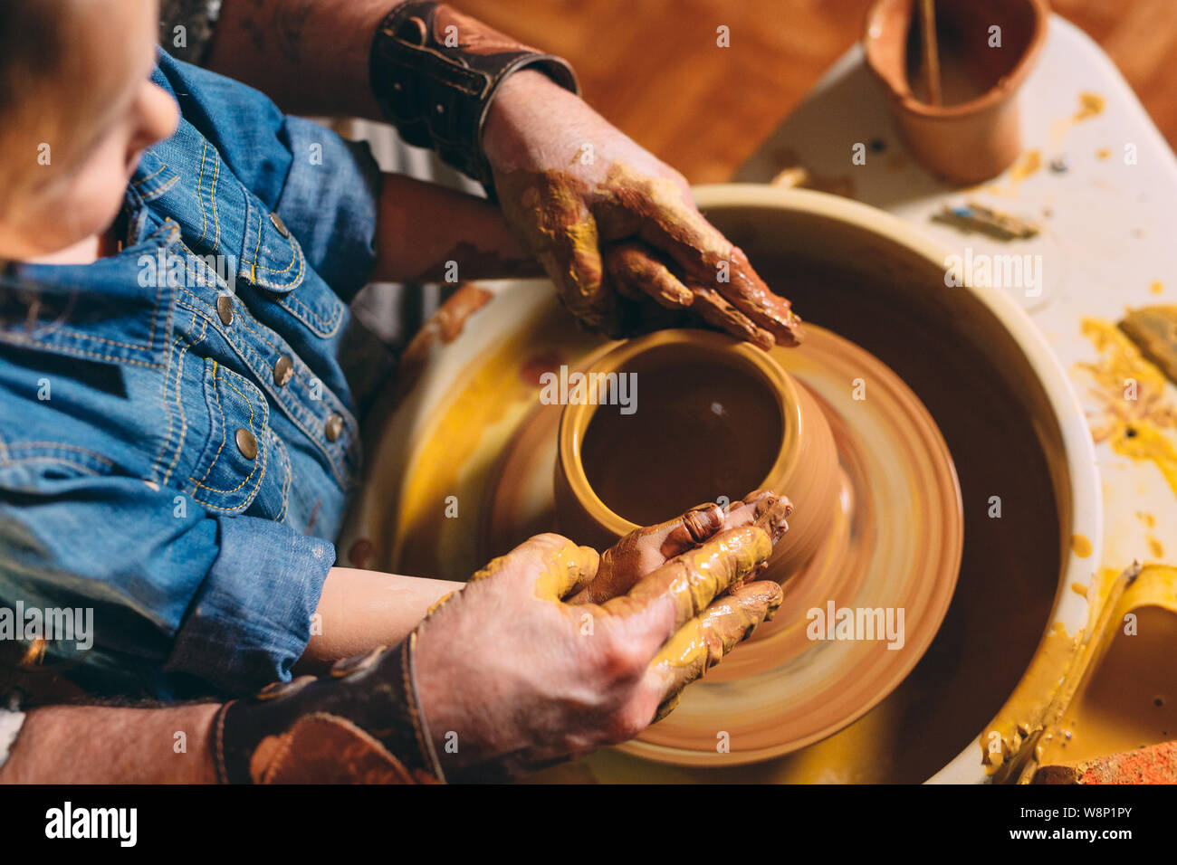 Pottery workshop. Grandpa teaches granddaughter pottery. Clay modeling ...
