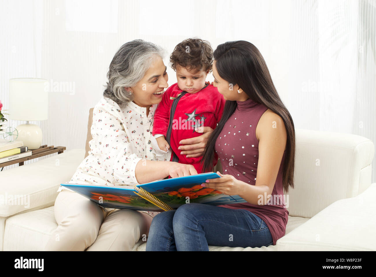 Family looking at family photo album Stock Photo - Alamy