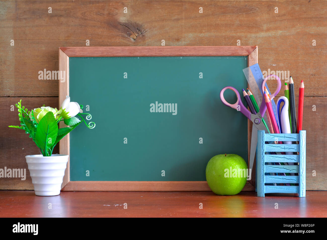 Back to School concept with apple on table in front of chalkboard Stock ...