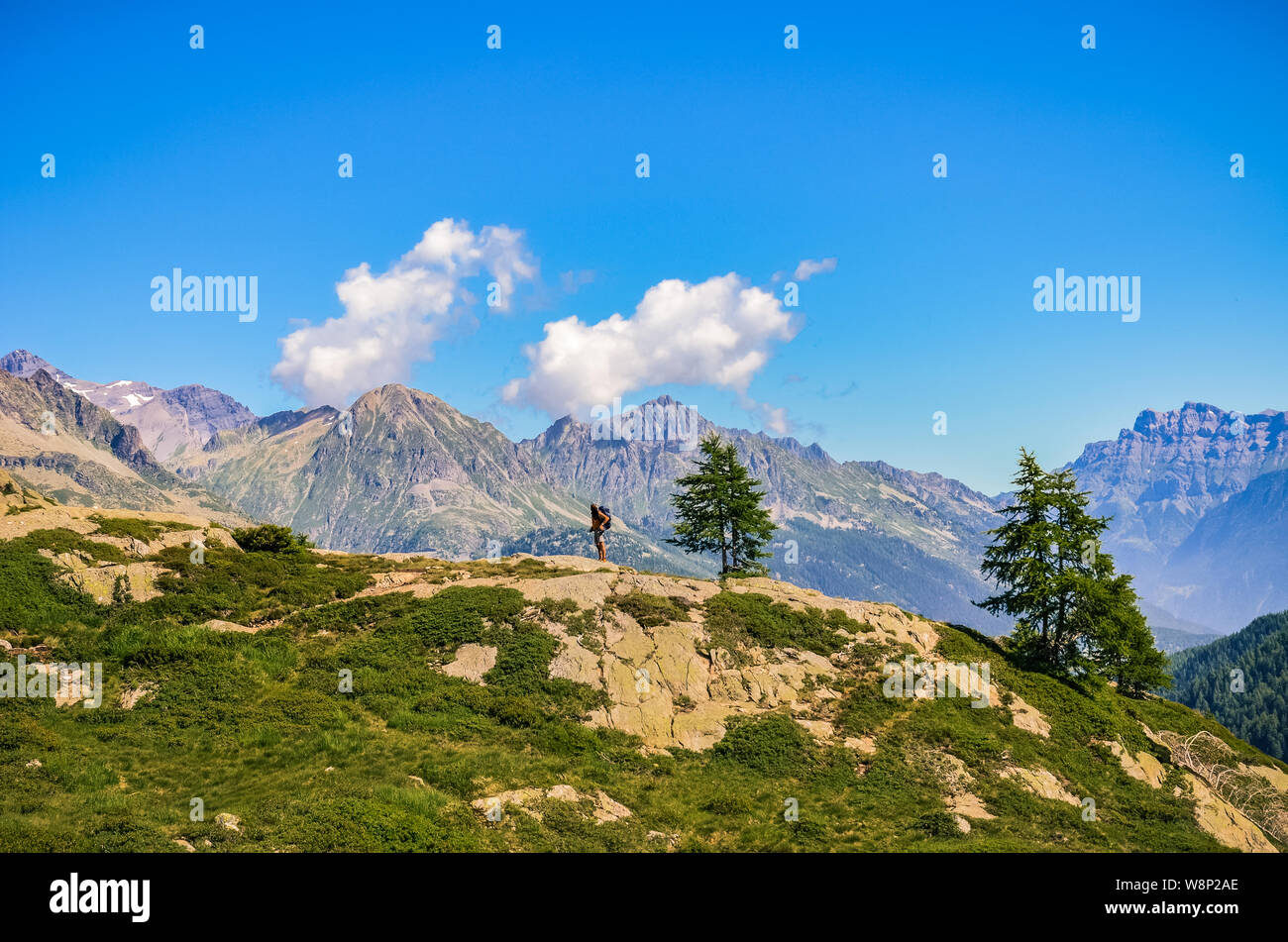 Lone man hiking in mountains on a beautiful sunny day. Standing on the ...