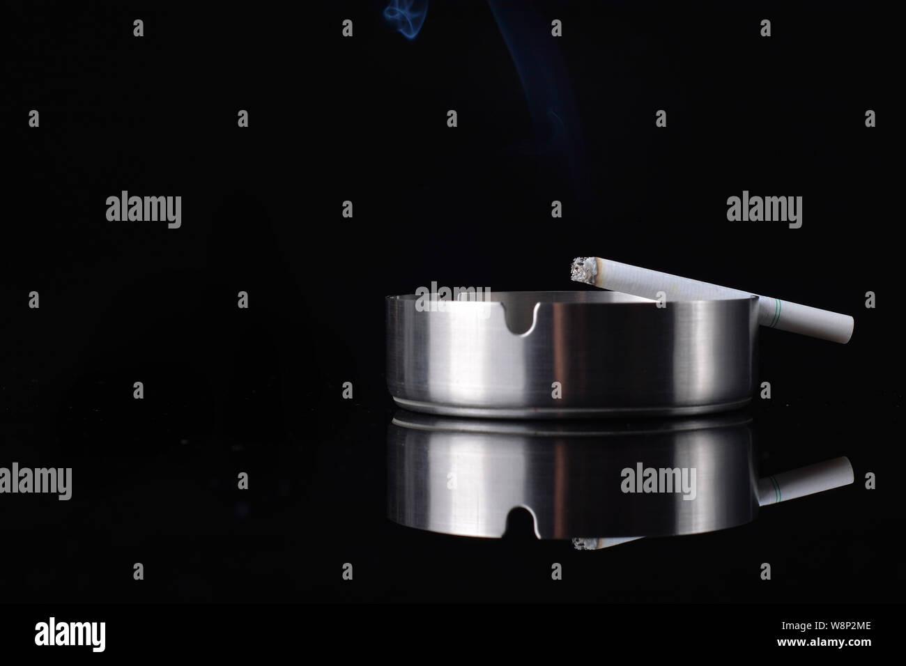 Smoke rising from a cigarette in an ashtray Stock Photo - Alamy