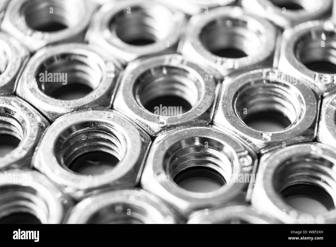 Metal nuts in a row background. Chromed screw nuts isolated. Steel nuts ...