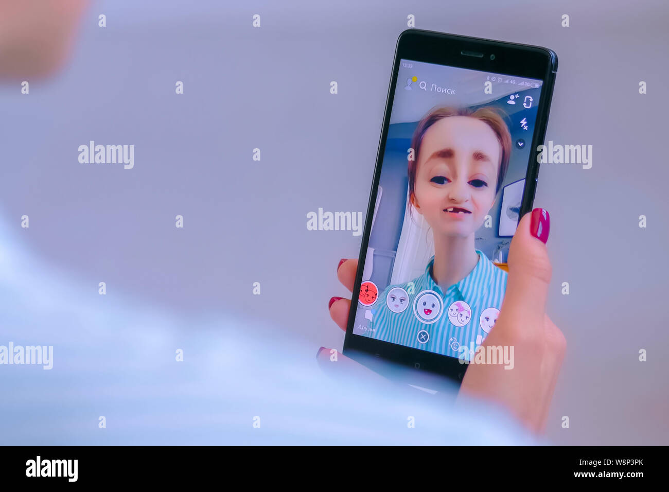 Woman using Snapchat multimedia messaging app with face mask on ...