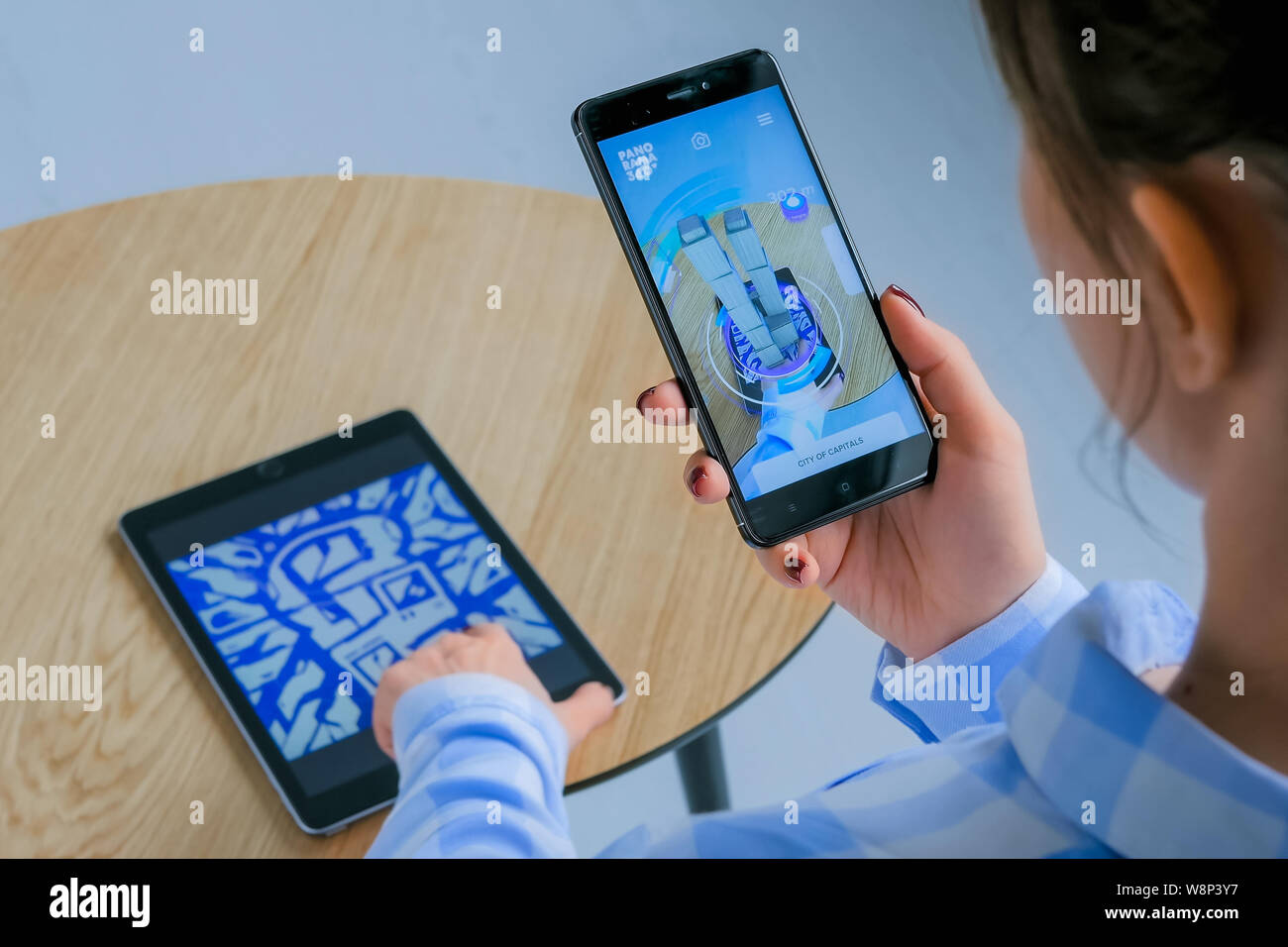 Woman using smartphone with augmented reality app and placing model of ...