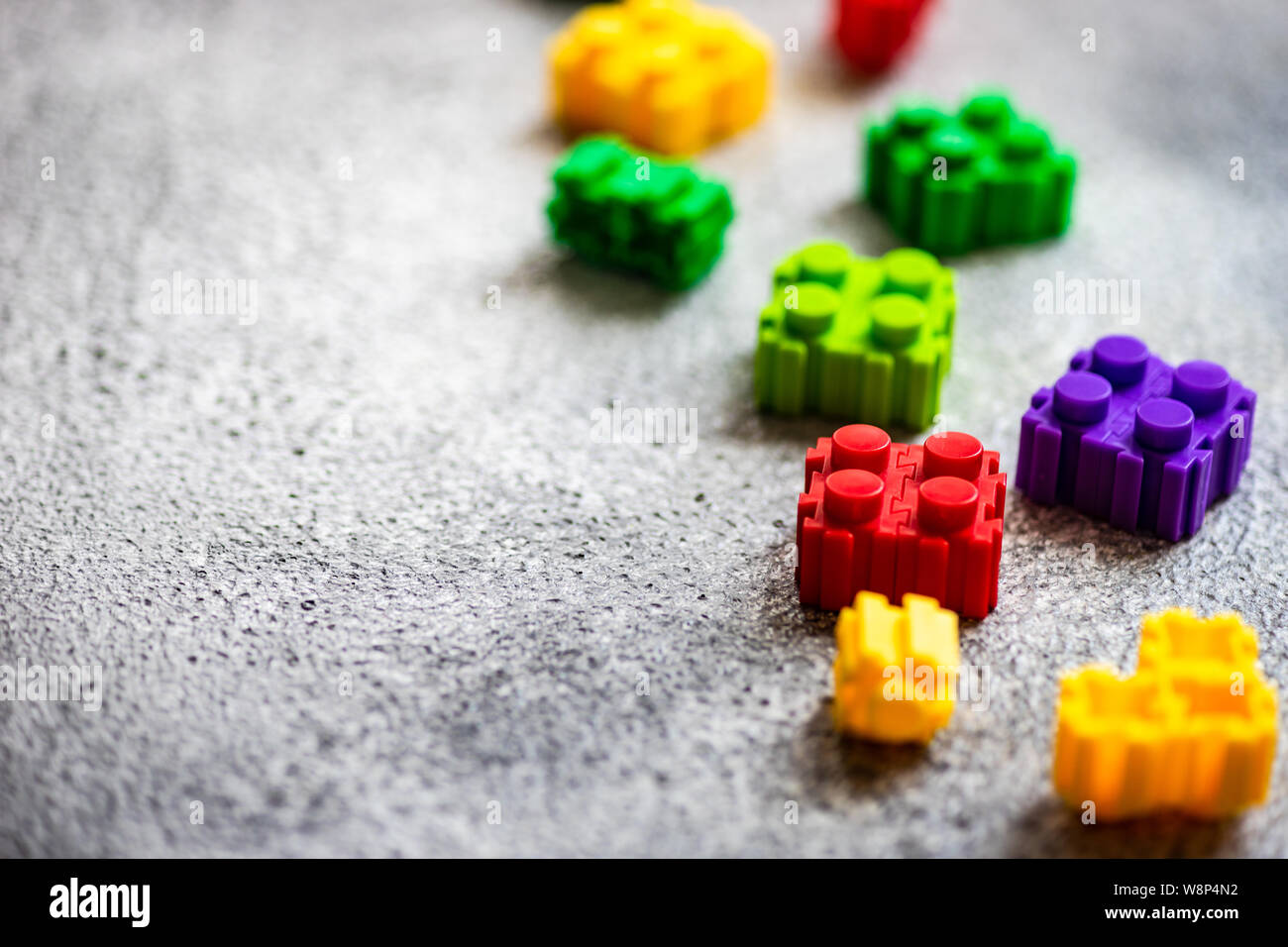 Kid concept with different colors toy blocks on concrete background ...