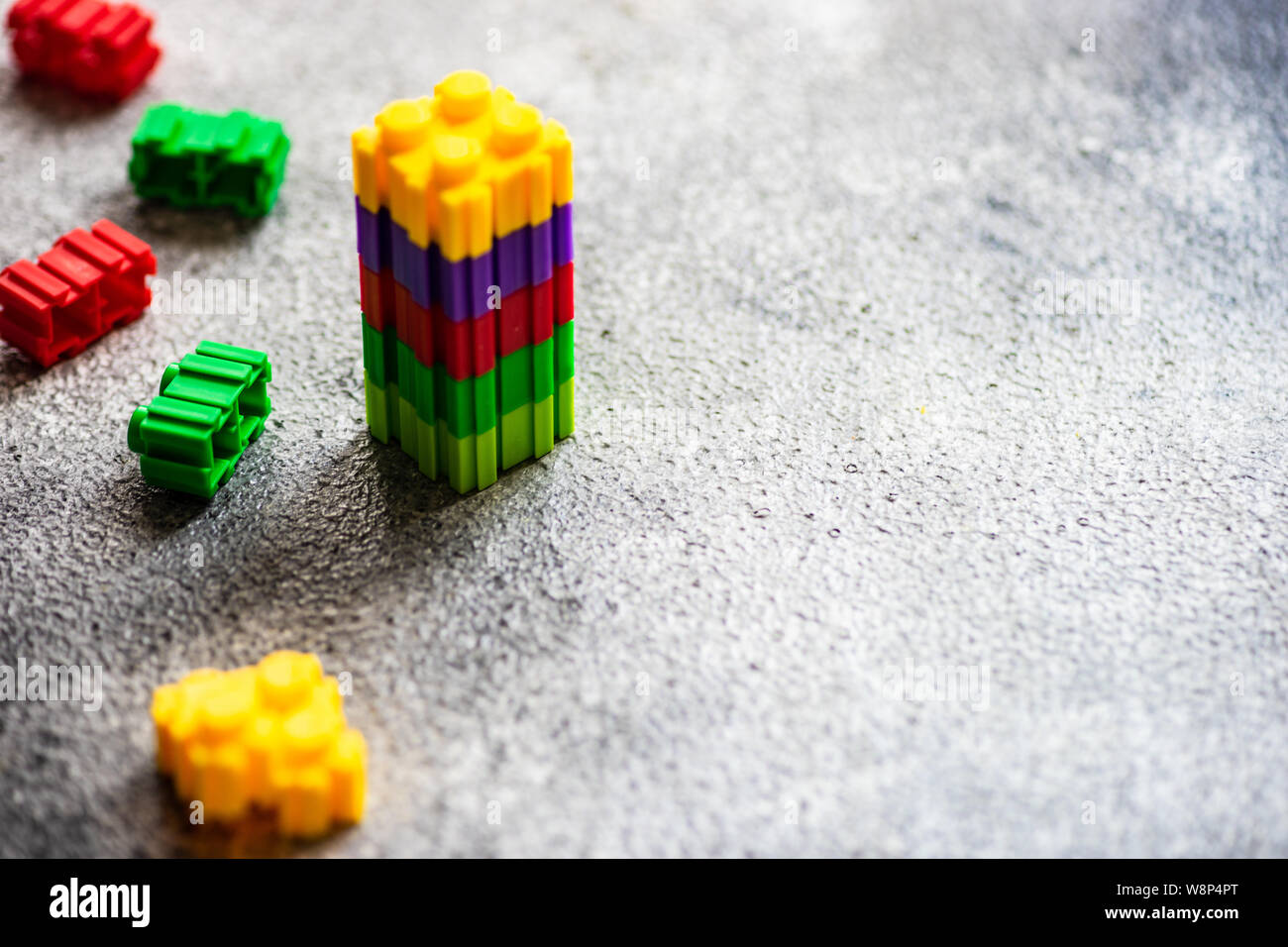 Kid concept with different colors toy blocks on concrete background ...