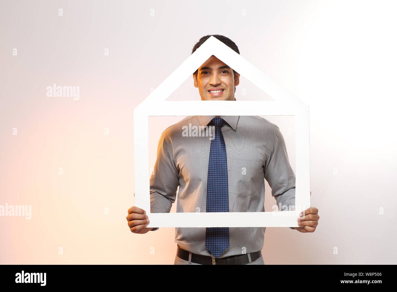 Businessman holding a dream home shape frame Stock Photo - Alamy