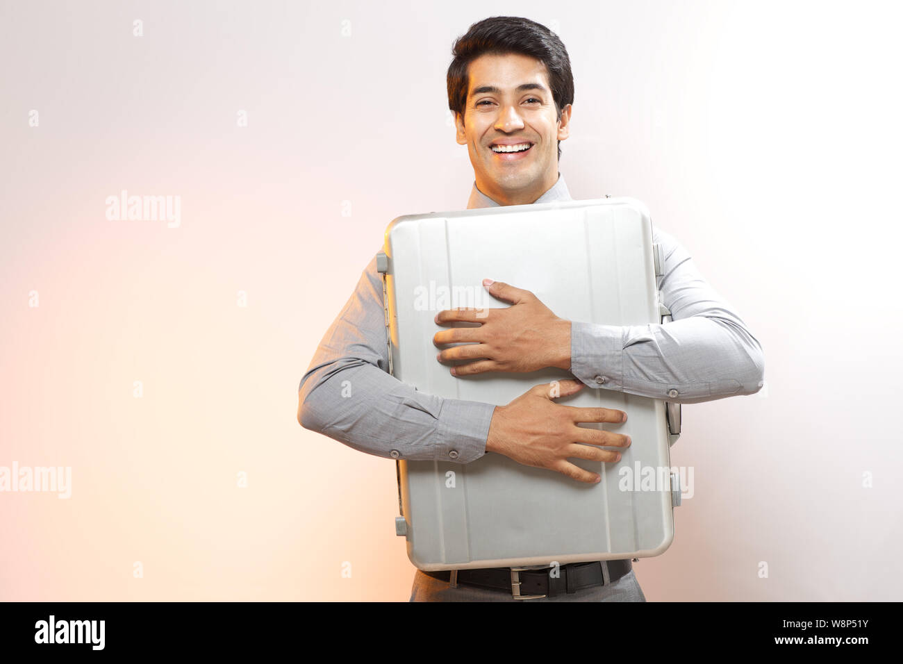 Businessman hugging a briefcase Stock Photo - Alamy