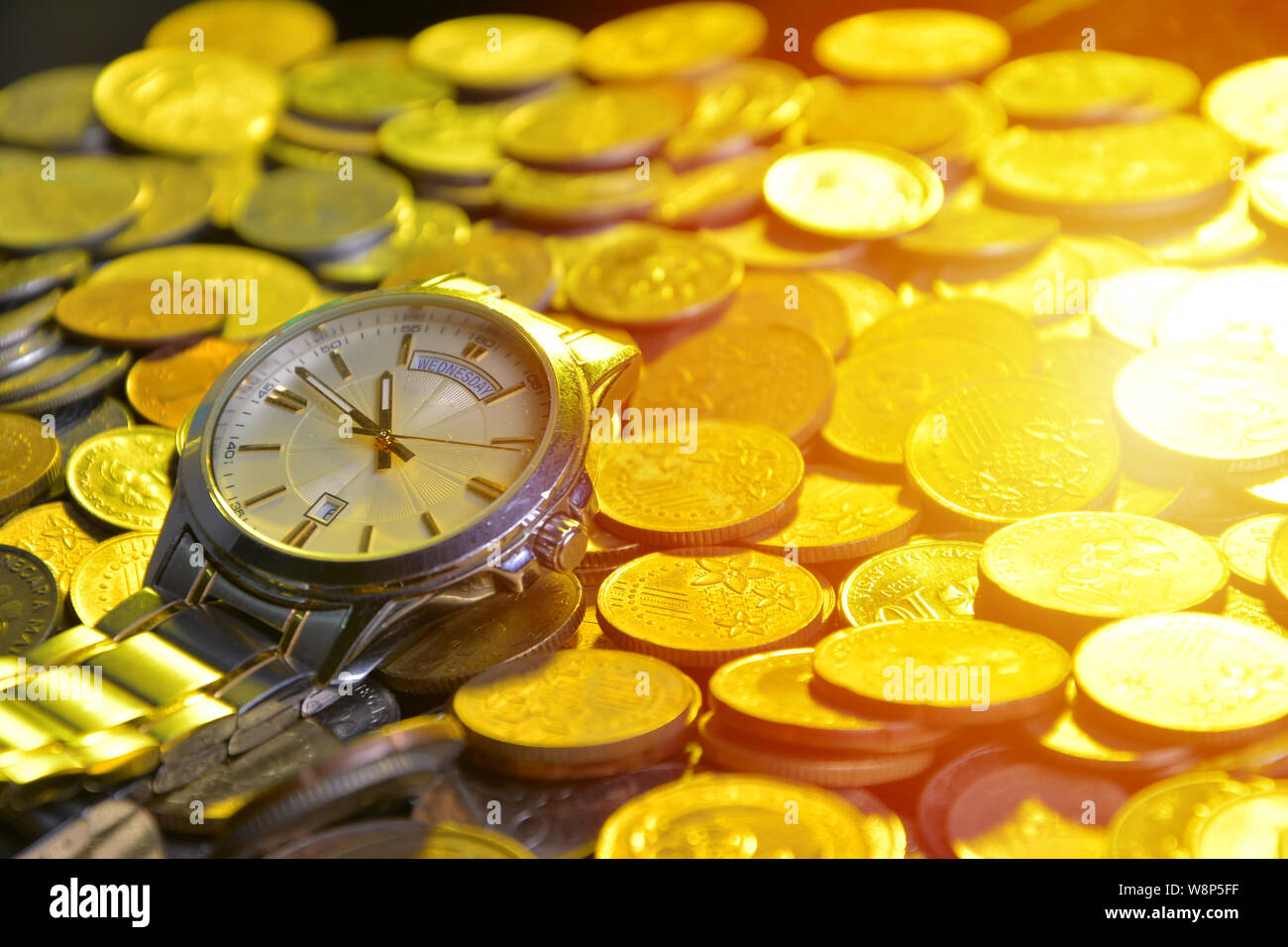 clock and stacks of coins : time - money Stock Photo - Alamy
