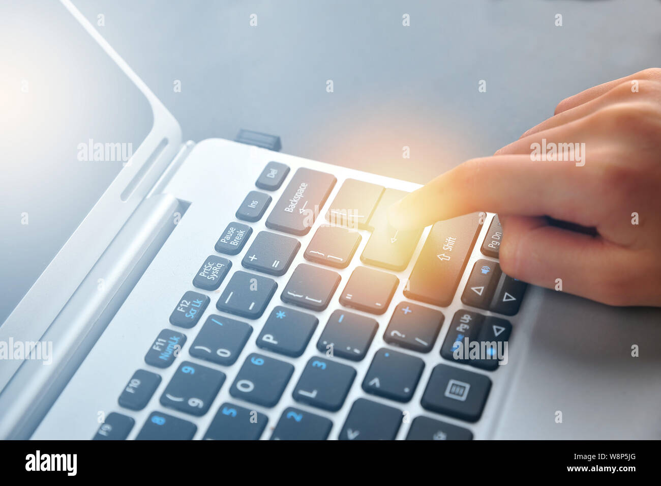 Woman hand touching laptop computer keyboard - Focus on the keyboard ...