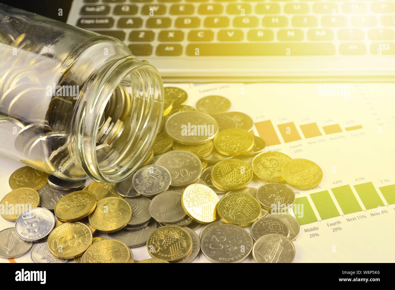 Coins spilling out of jar on the business stock charts - Business ...