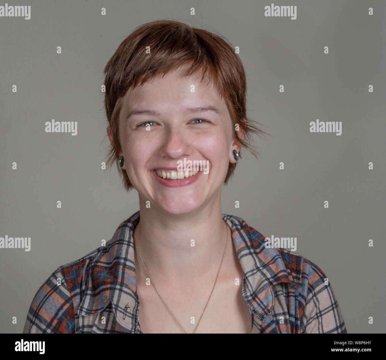 A young woman with a friendly, honest face smiles in a simple head-and ...